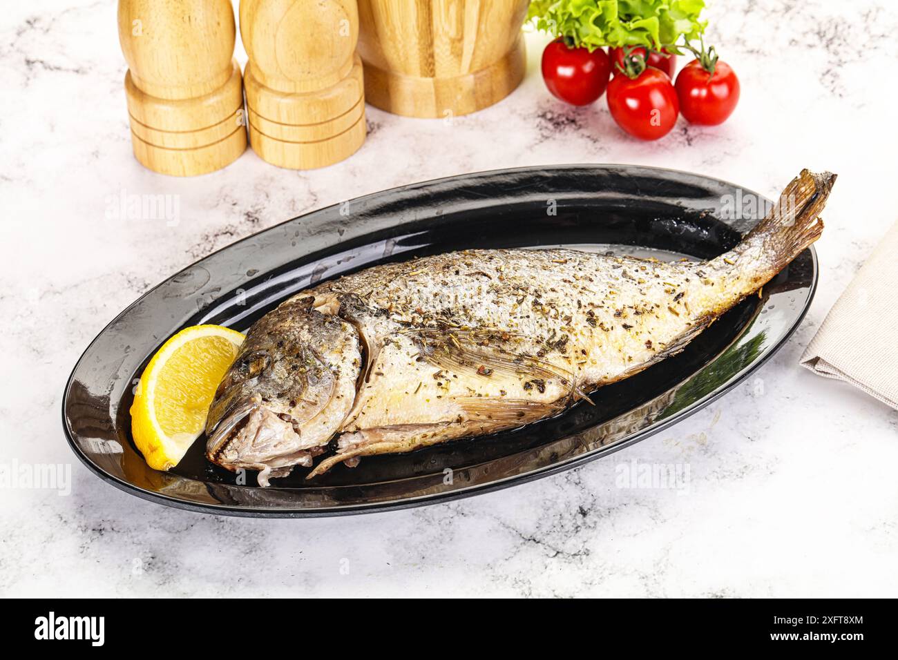 Baked Dorado fish served lemon slice Stock Photo - Alamy