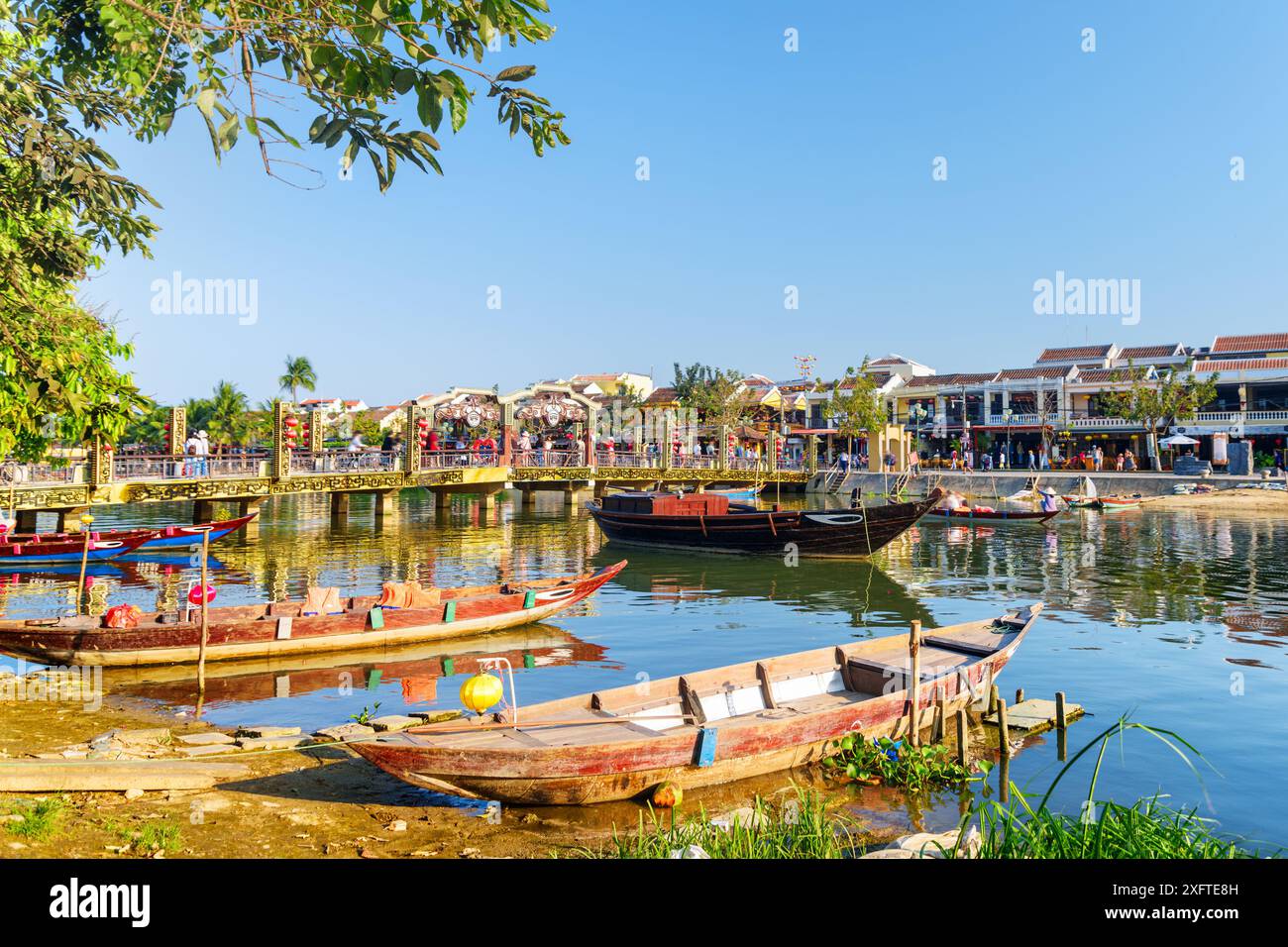 Tourist wooden boats and scenic bridge over the Thu Bon River in Hoi An ...