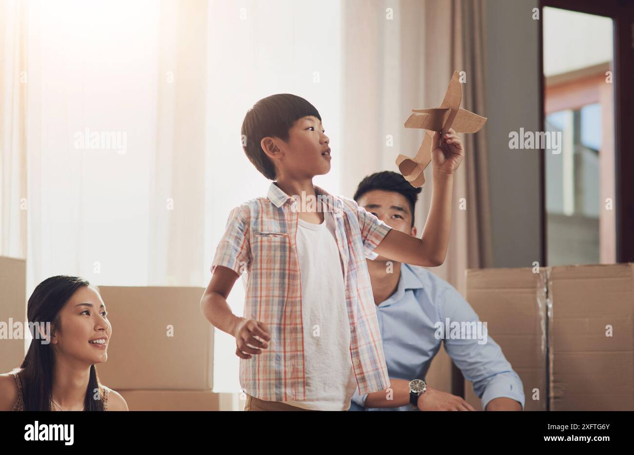 New home, Asian family and boy with cardboard plane, playful and fun ...
