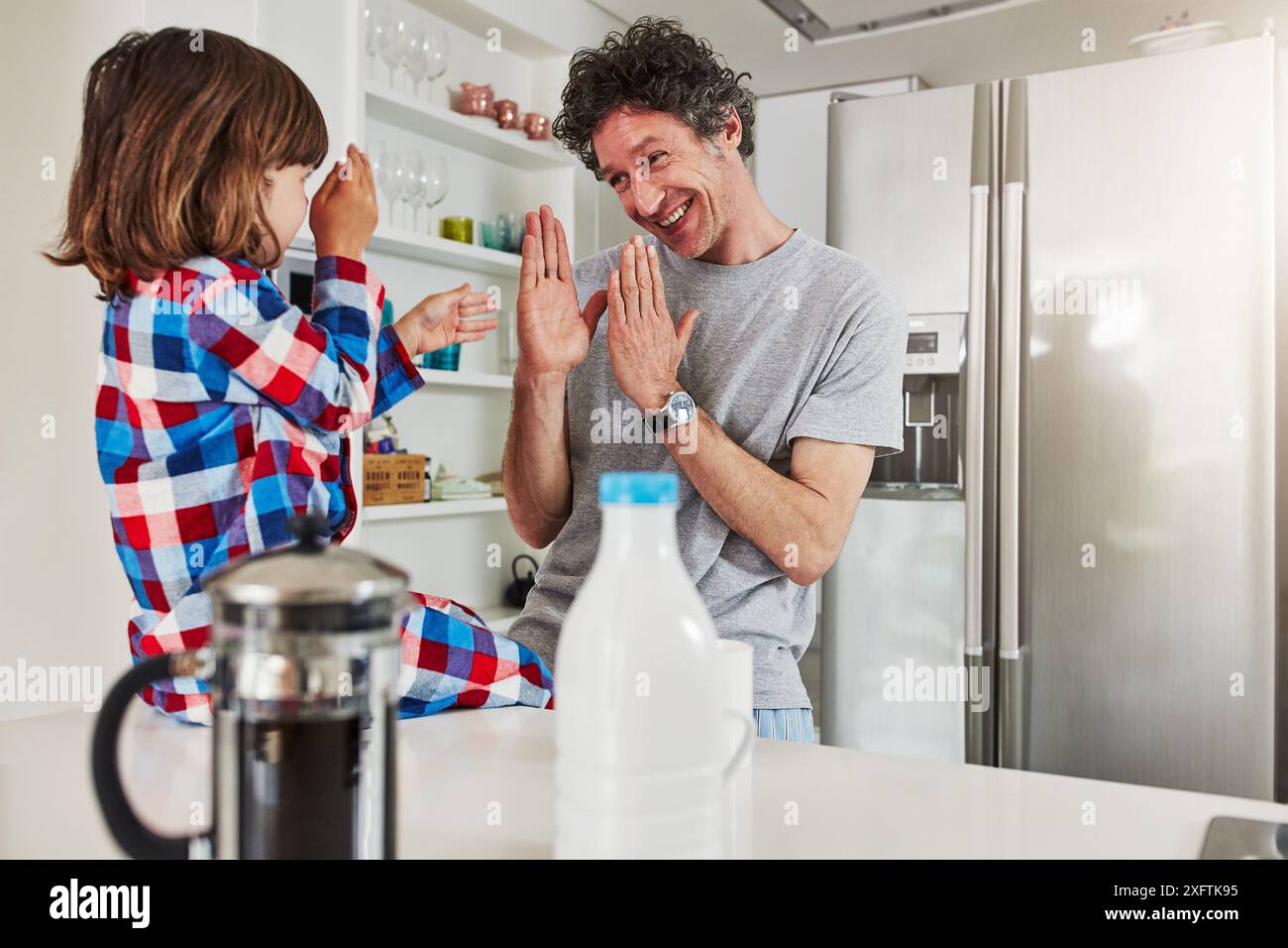 Child, clapping and dad in kitchen of home, song and singing or nursery ...