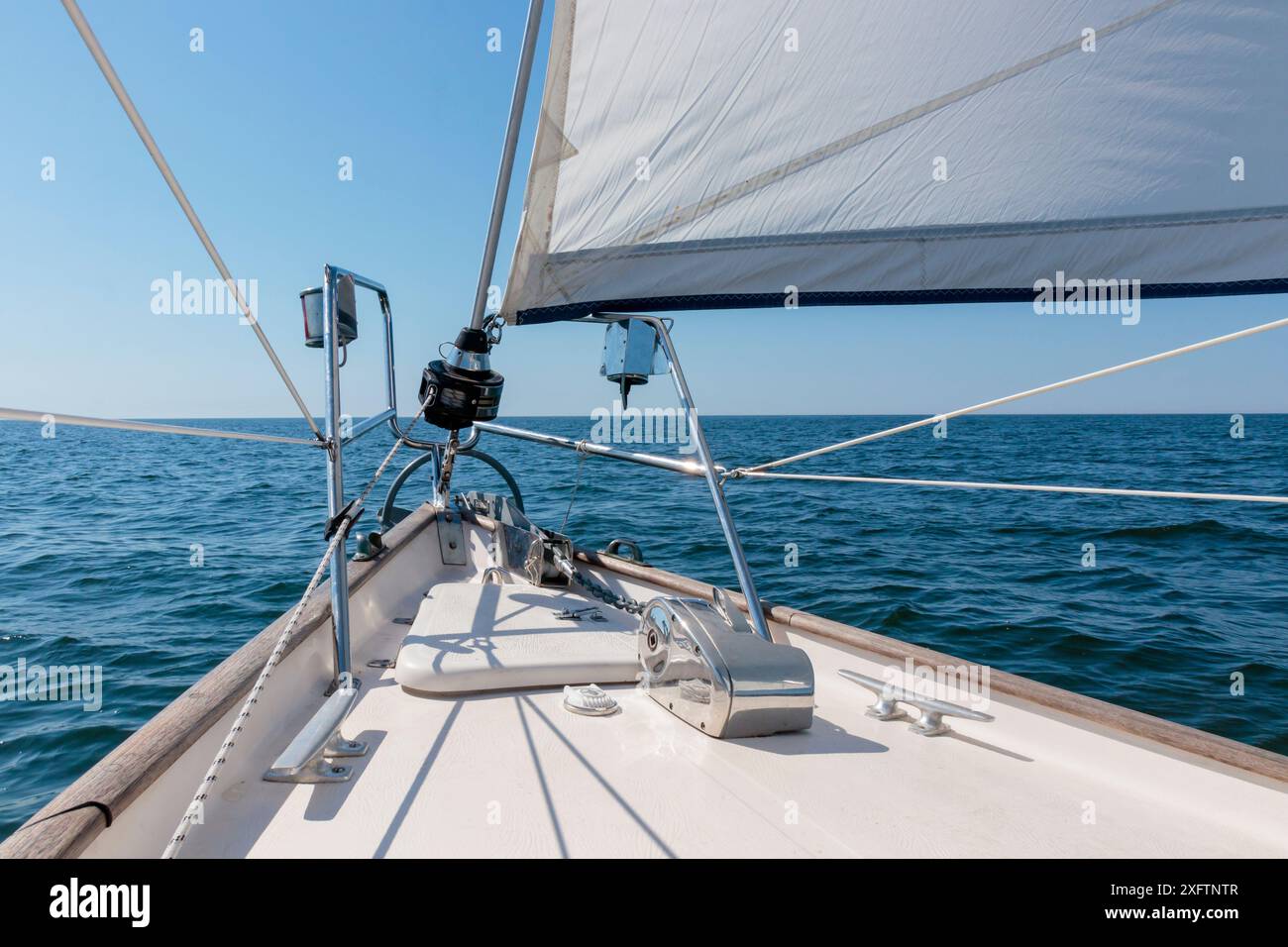 White yacht sailing on a sunny summer day. Top down view from the deck ...