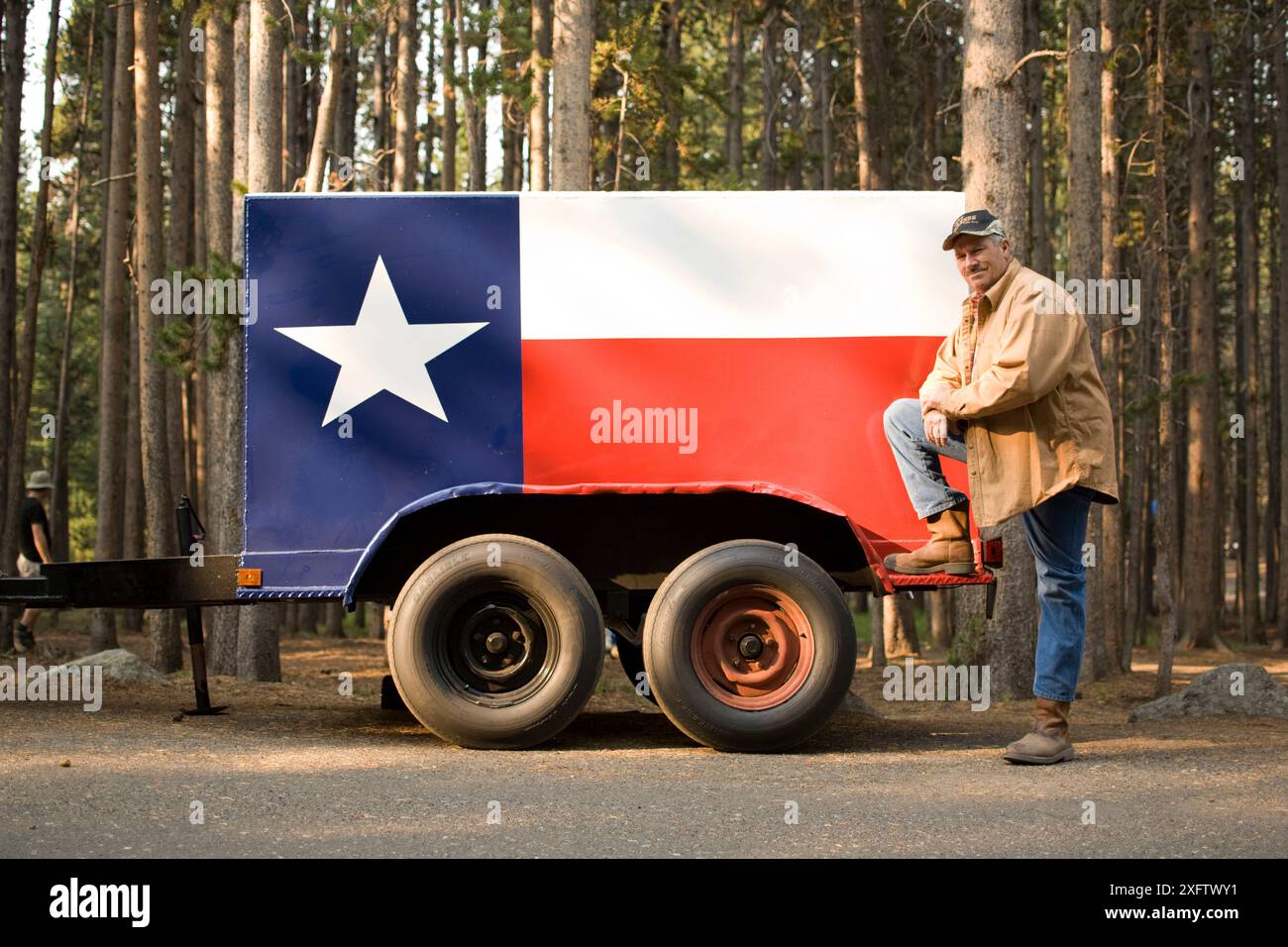 A man poses in front of his custom painted Texas Flag trailer in WY ...