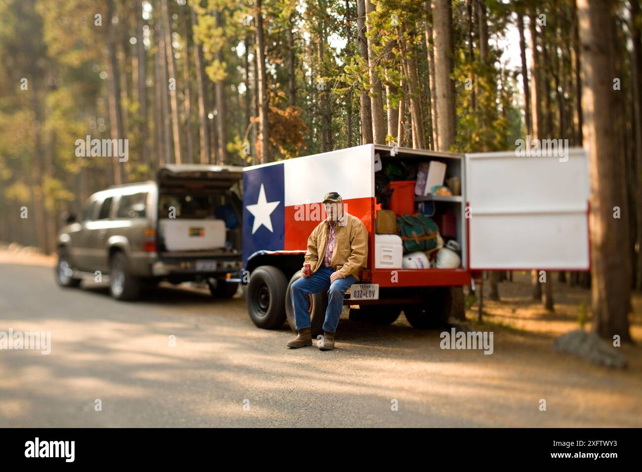 A man poses in front of his custom painted Texas Flag trailer in WY ...