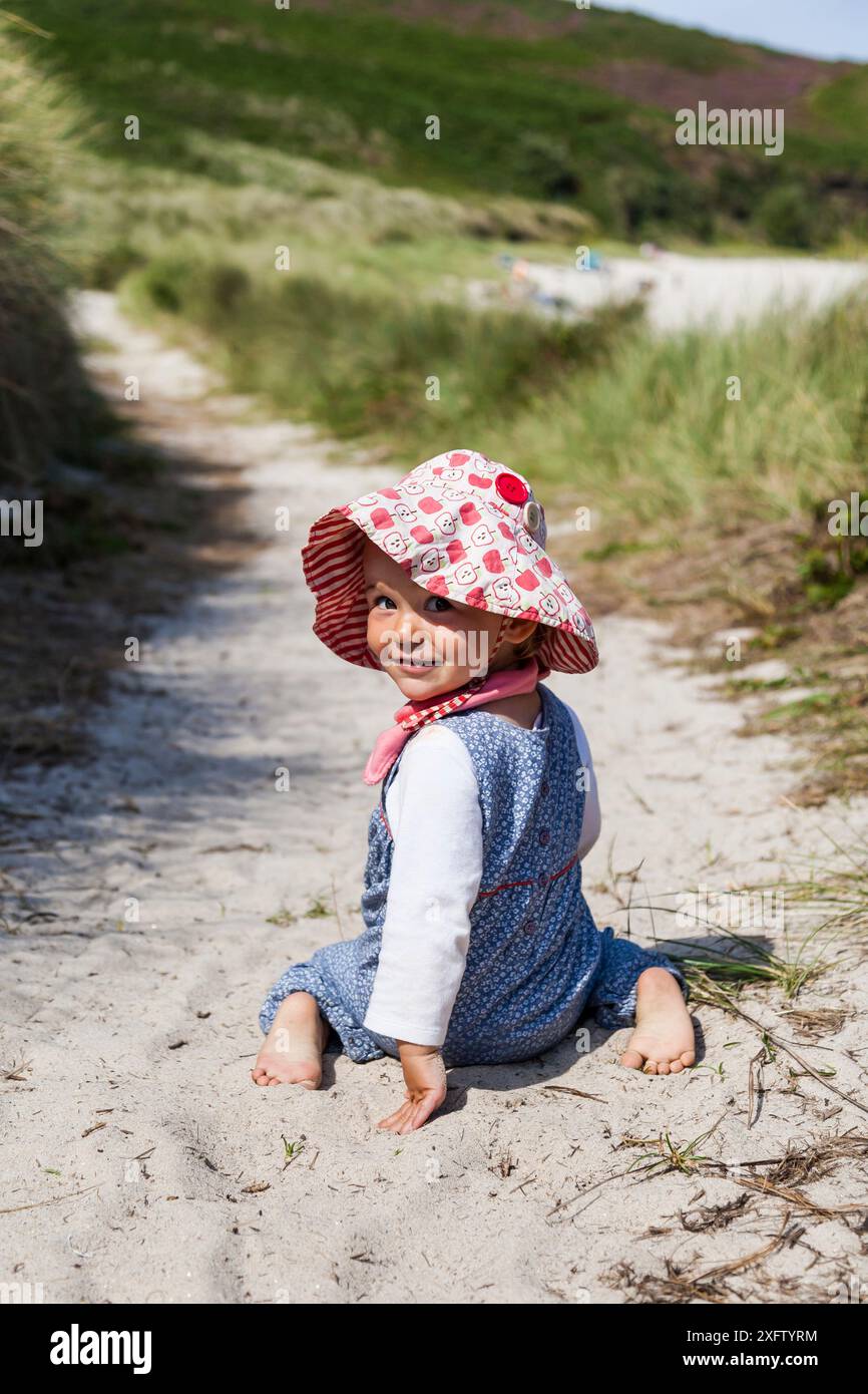 Girl, aged 16 months, sitting on path to Little Bay, St. Martin's ...
