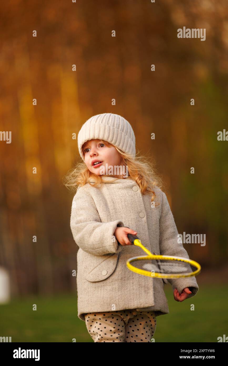 A little girl is playing badminton on the playground in the park Stock ...