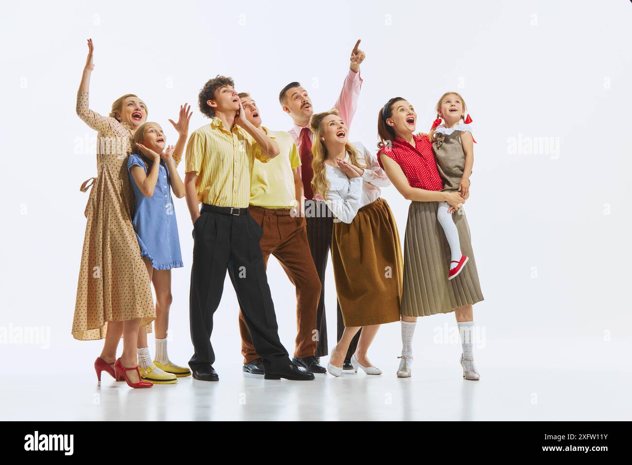A group of people in vintage attire pointing and looking upwards with ...