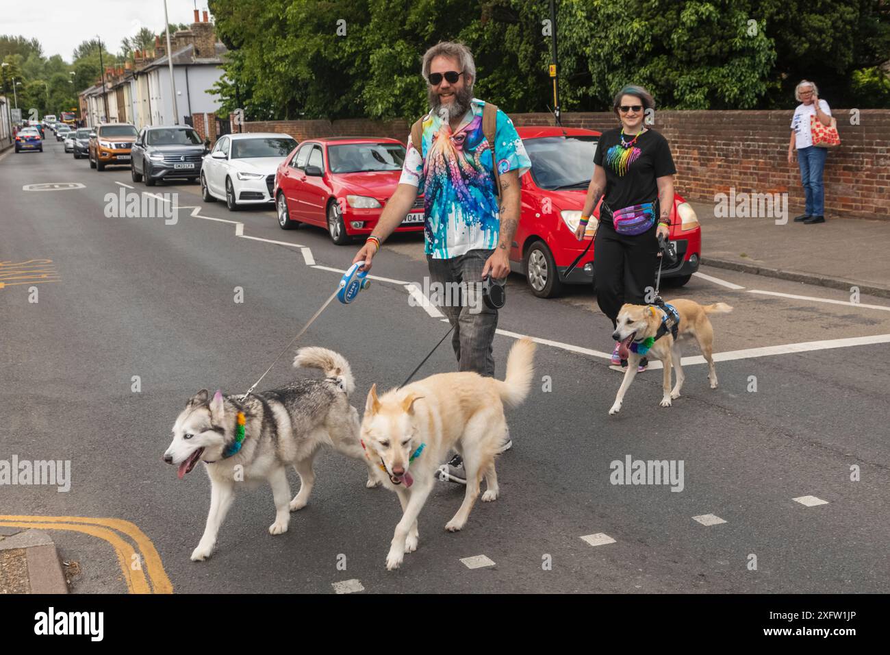 England, Kent, Canterbury, Colourful couple crossing road with three ...