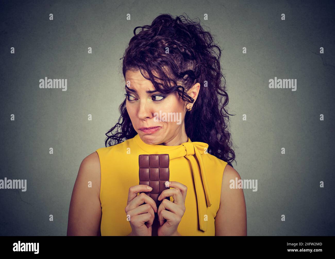 Portrait of a woman craving a sweet chocolate, feeling remorse Stock ...