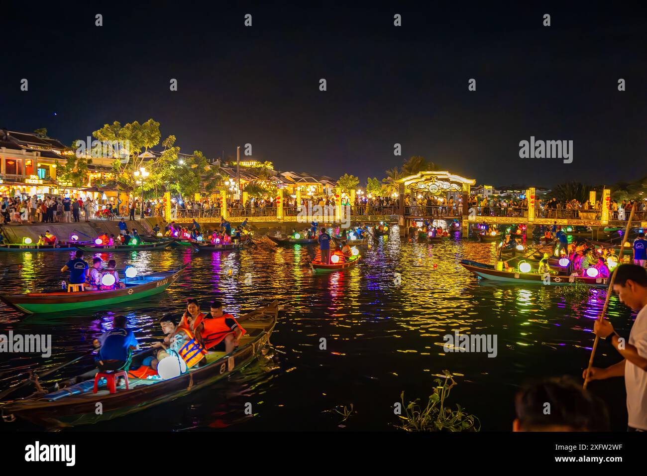 View of the street in Hoi An ancient town at night with lantern boats ...