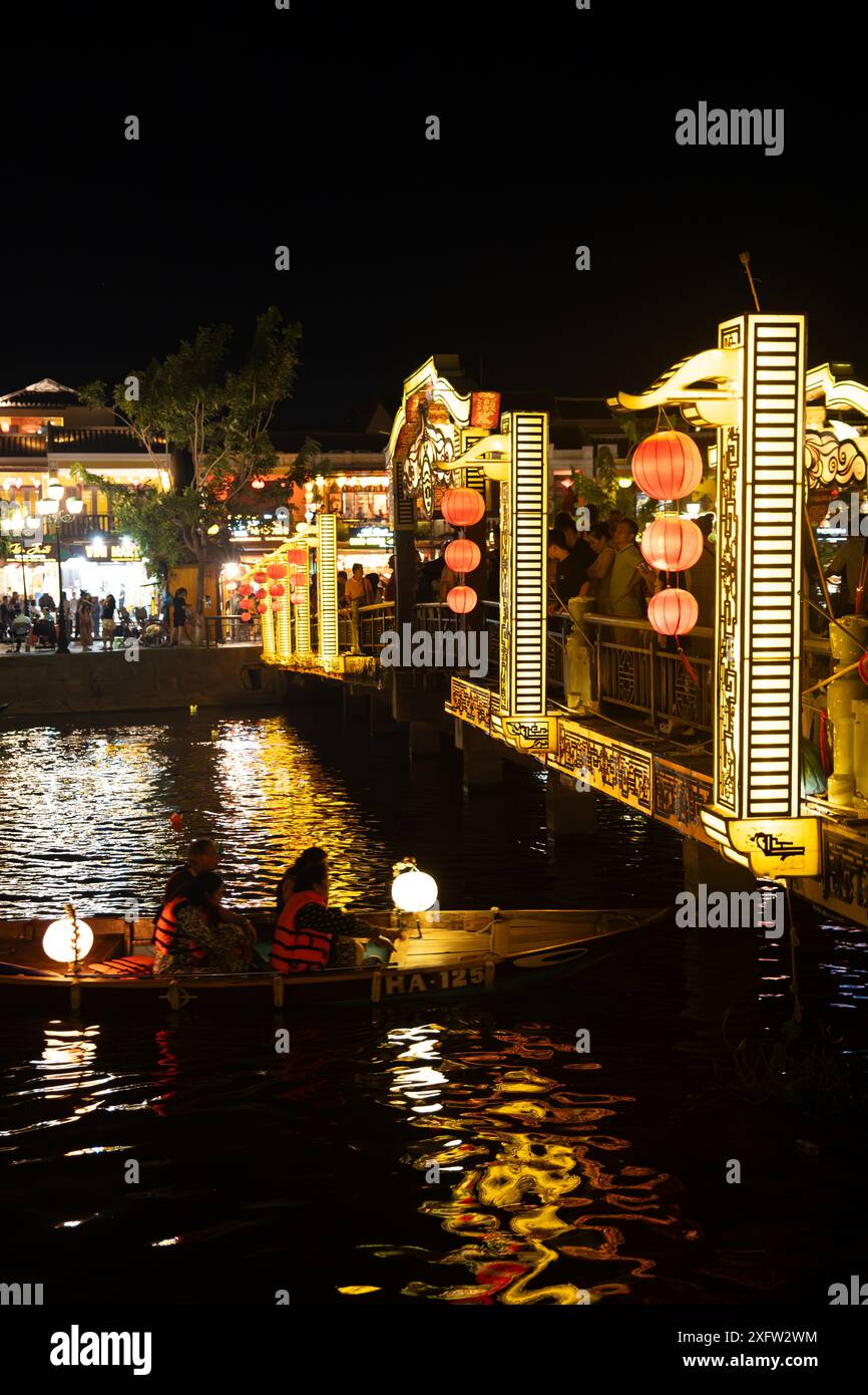 View of the street in Hoi An ancient town at night with lantern boats ...