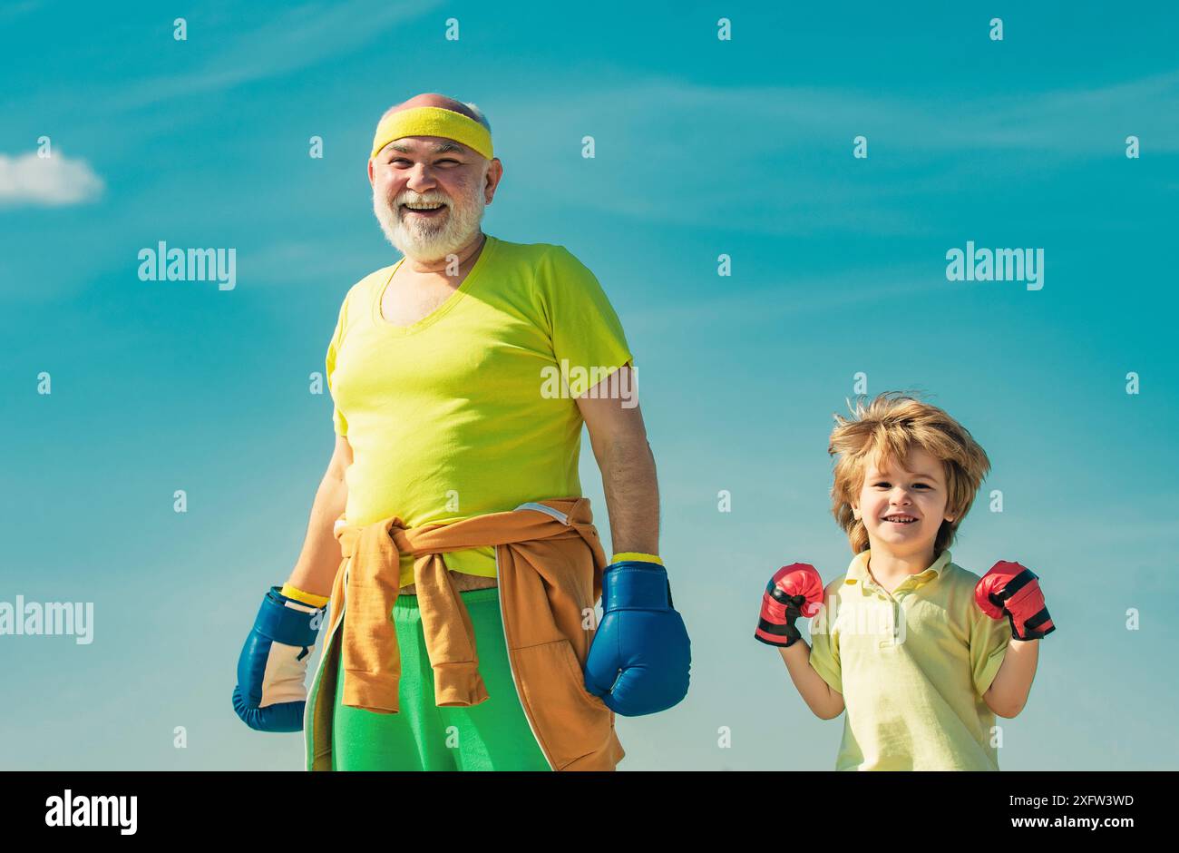 Older - young man boxing. Handsome elderly man practicing boxing kicks ...