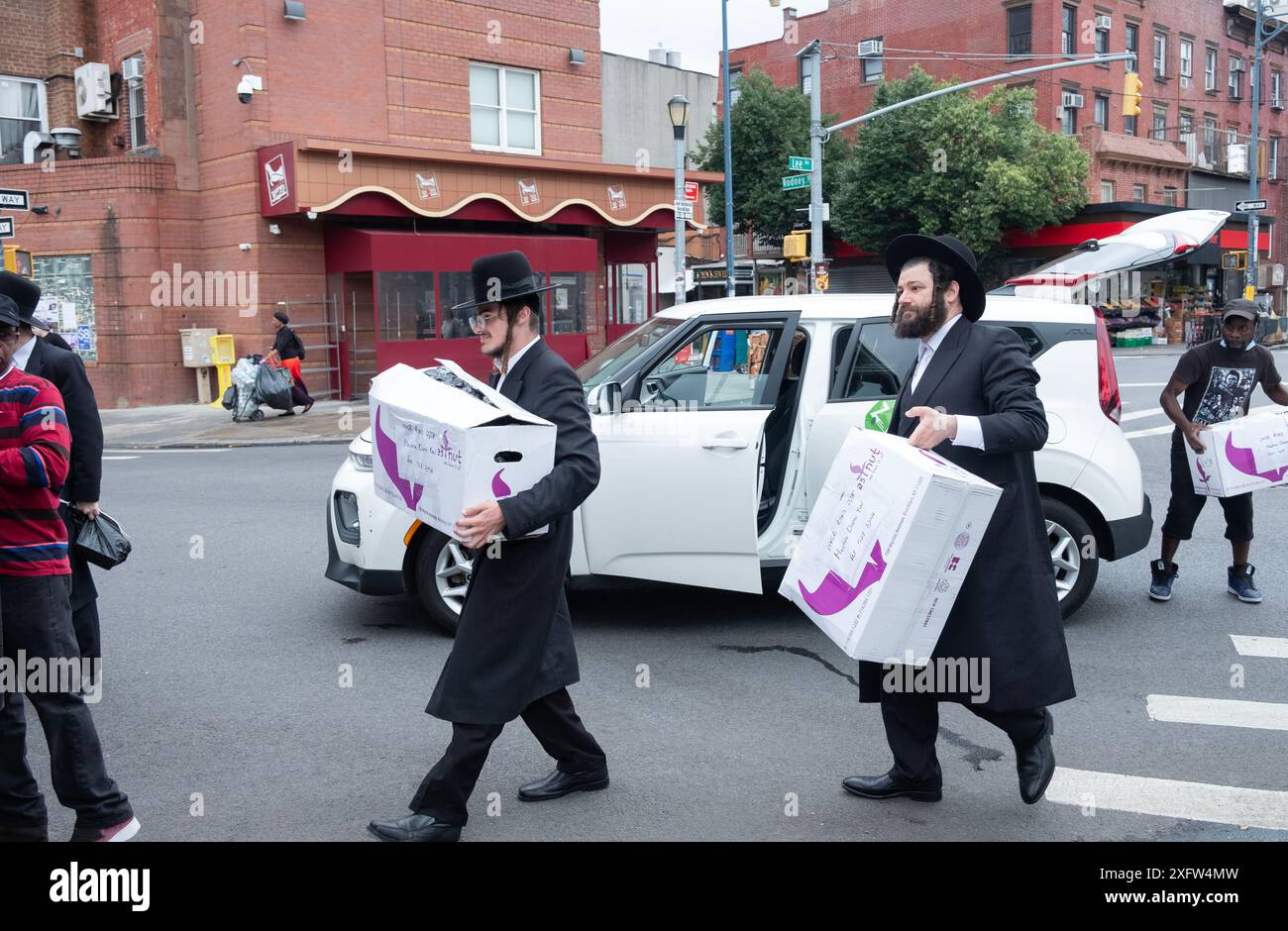 Hasidic Jewish men carry boxes for their younger siblings to be ...