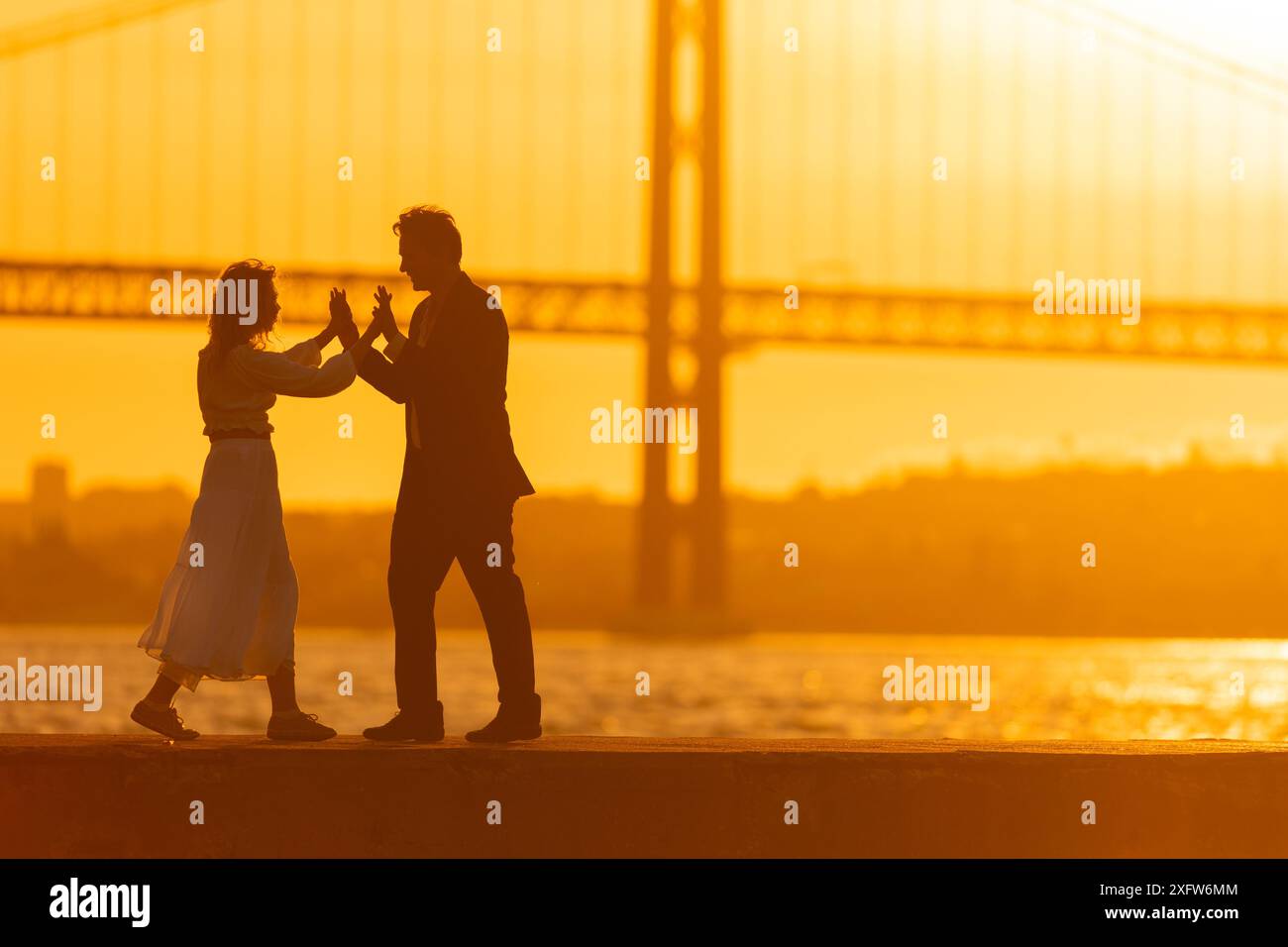 Couple Dancing at Sunset by a Bridge Stock Photo - Alamy