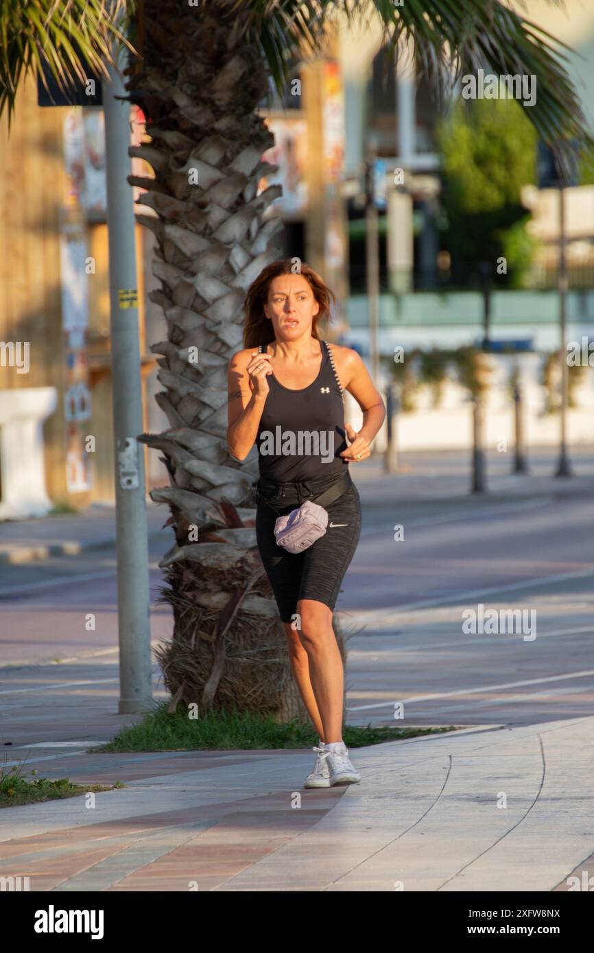 Urban jogging scene with middle-aged woman running Stock Photo - Alamy