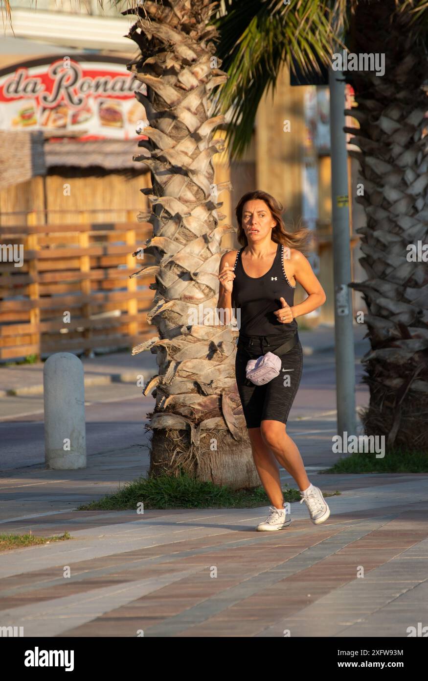 Urban jogging scene with middle-aged woman running Stock Photo - Alamy