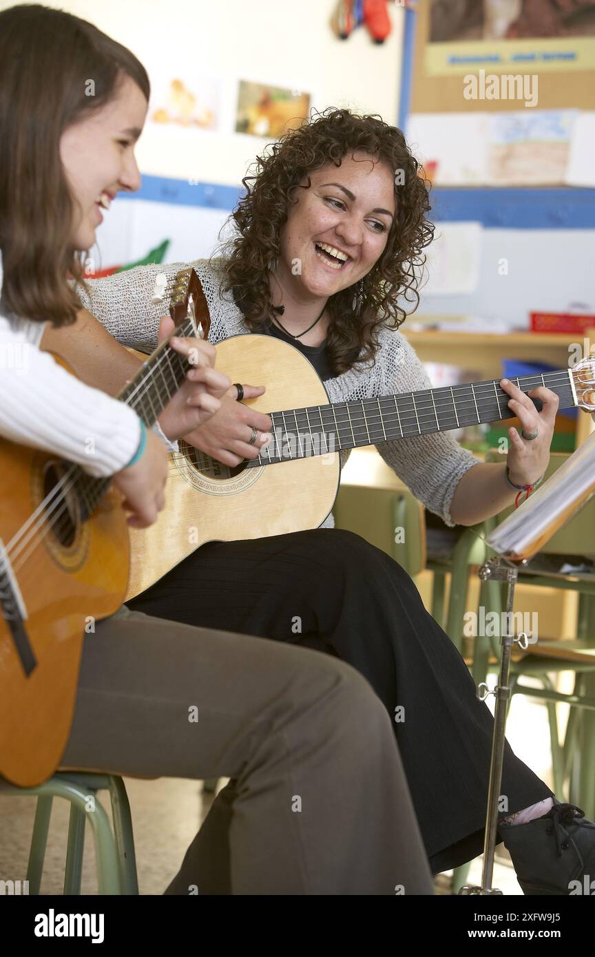 Music teacher, guitar instruction Stock Photo - Alamy