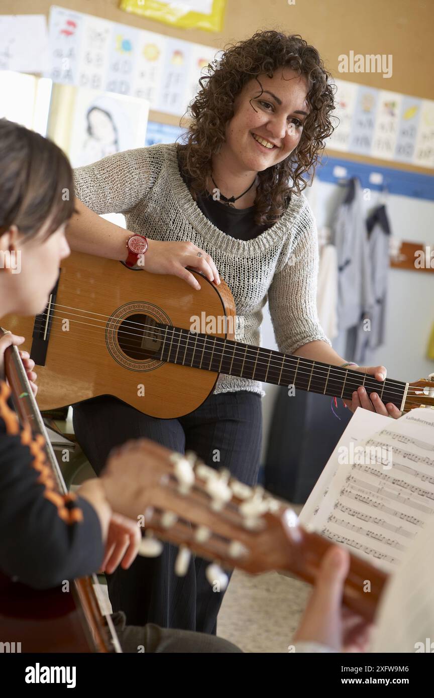 Music teacher, guitar instruction Stock Photo - Alamy
