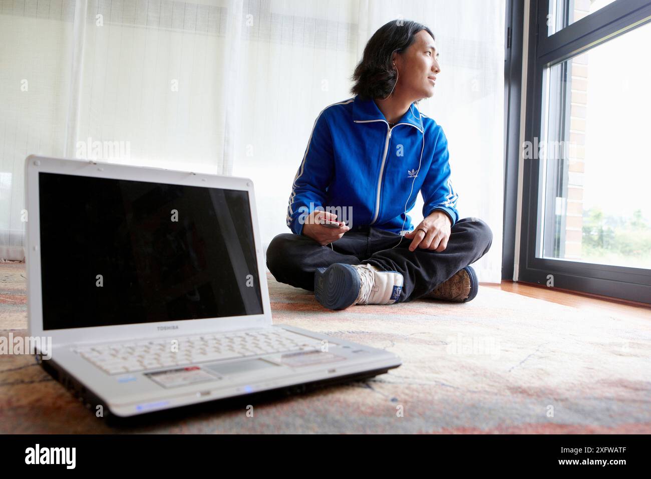 Young Japanese man with laptop computer in room Stock Photo - Alamy