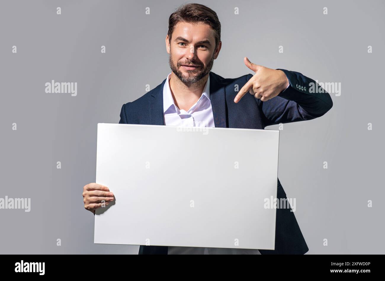 Man showing promo holding pointing finger on blank board on studio ...
