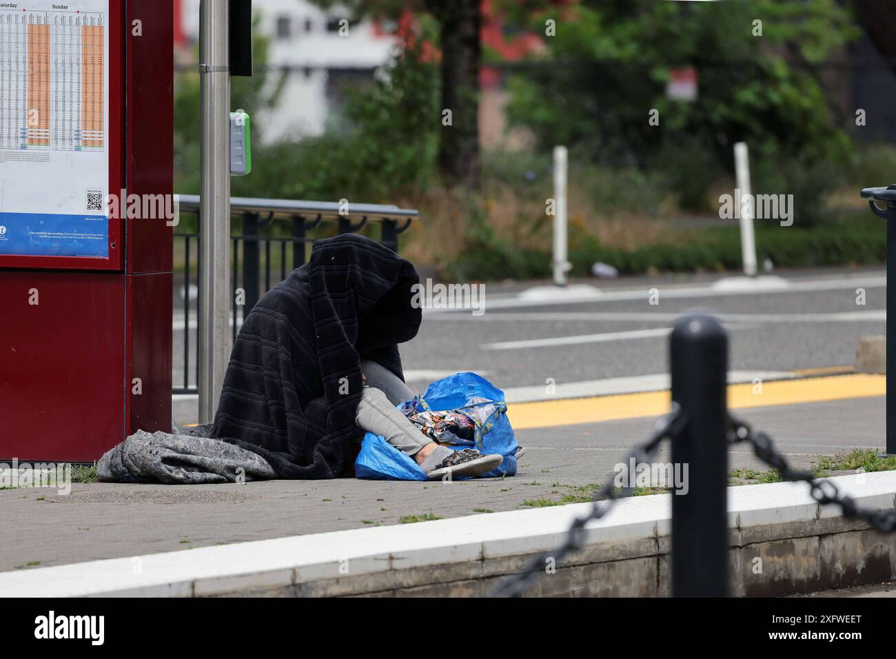 Obdachloser sitzt auf dem Boden an der Tri Met Max ...