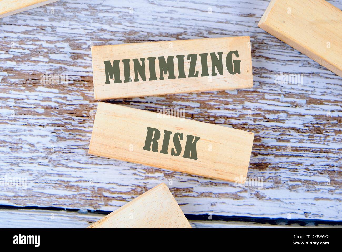 MINIMIZING RISK text on wooden blocks on old boards Stock Photo - Alamy