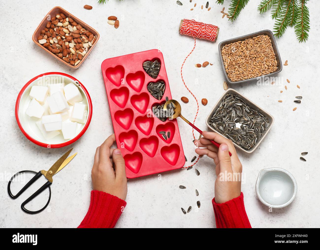 Step 1. Child filling the heart bar form with sunflower seeds. Step by ...