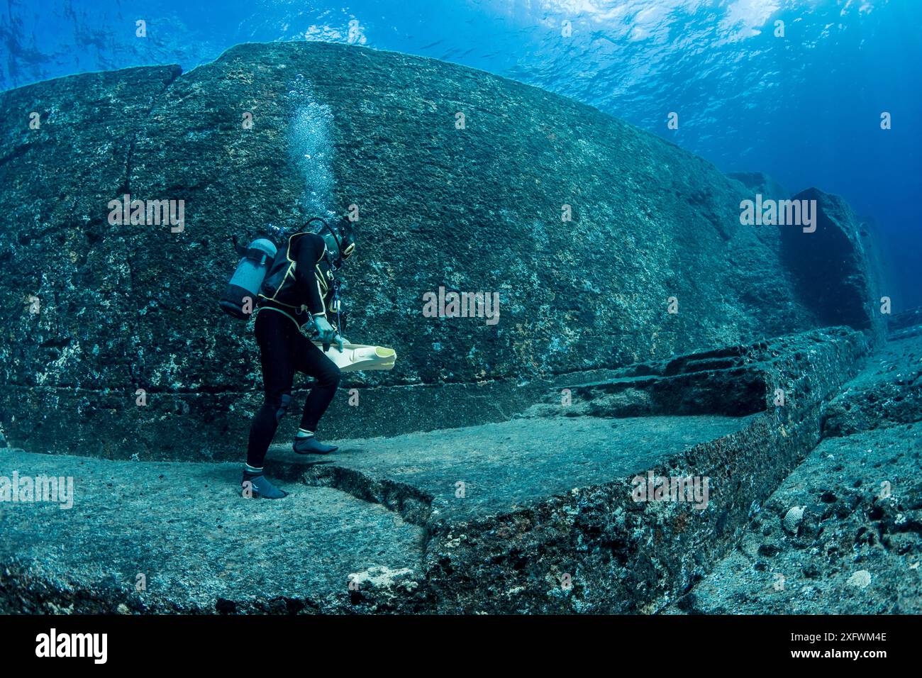 Scuba diver exploring the Yonaguni Monument, a submerged rock formation ...