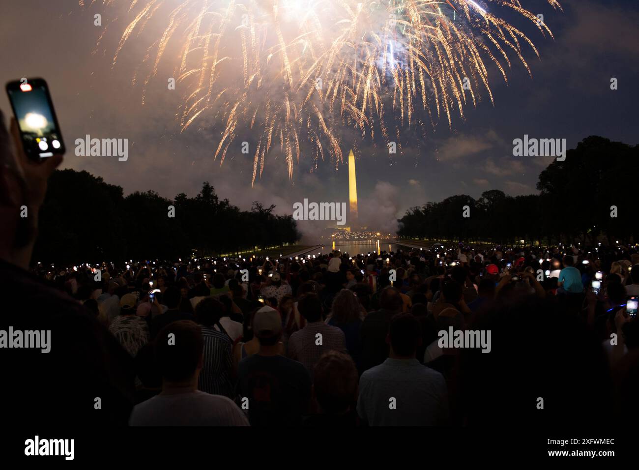 Attendees watch the Independence Day fireworks display along the ...