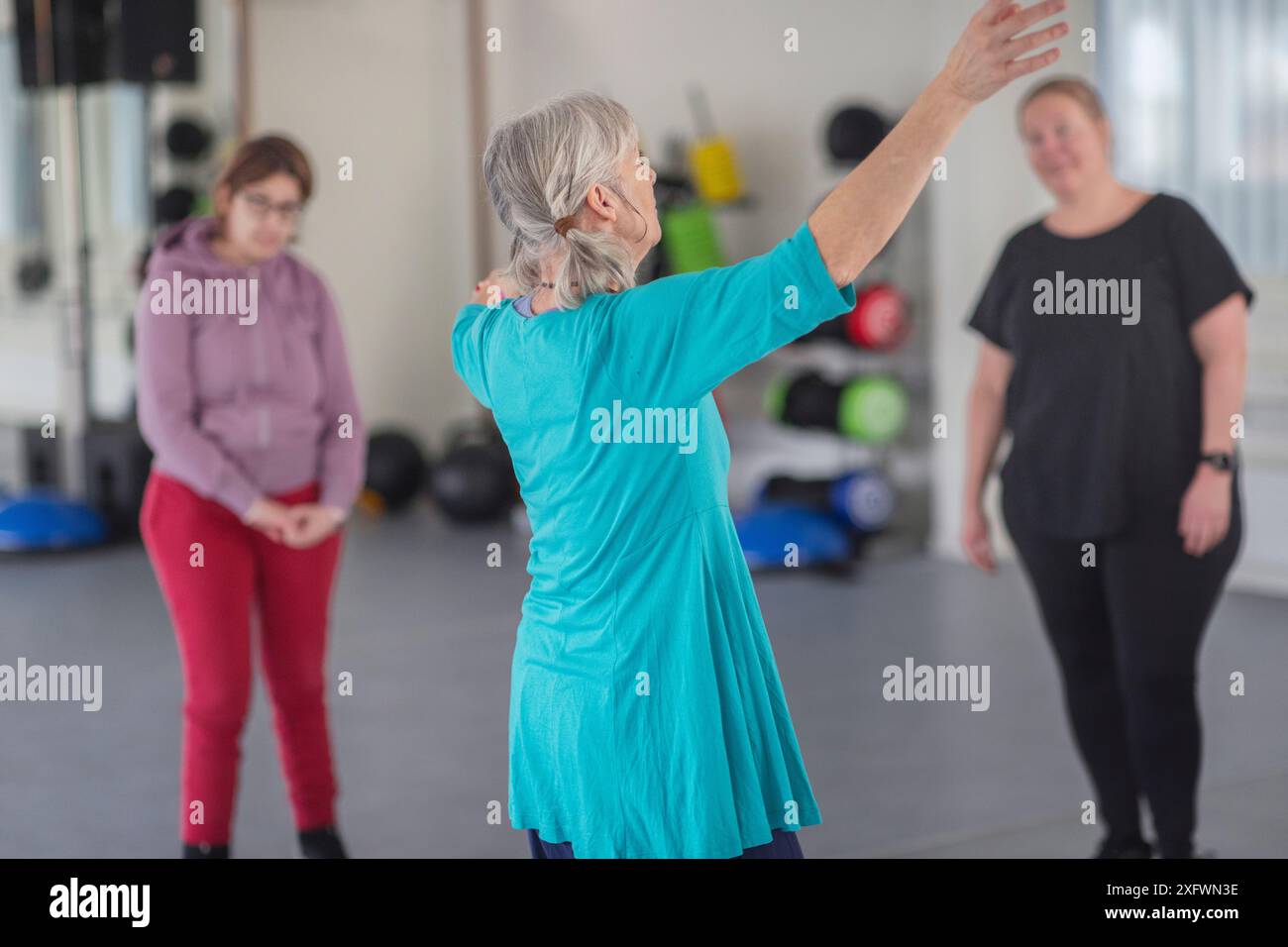 Female instructor explaining students at dance studio Stock Photo - Alamy