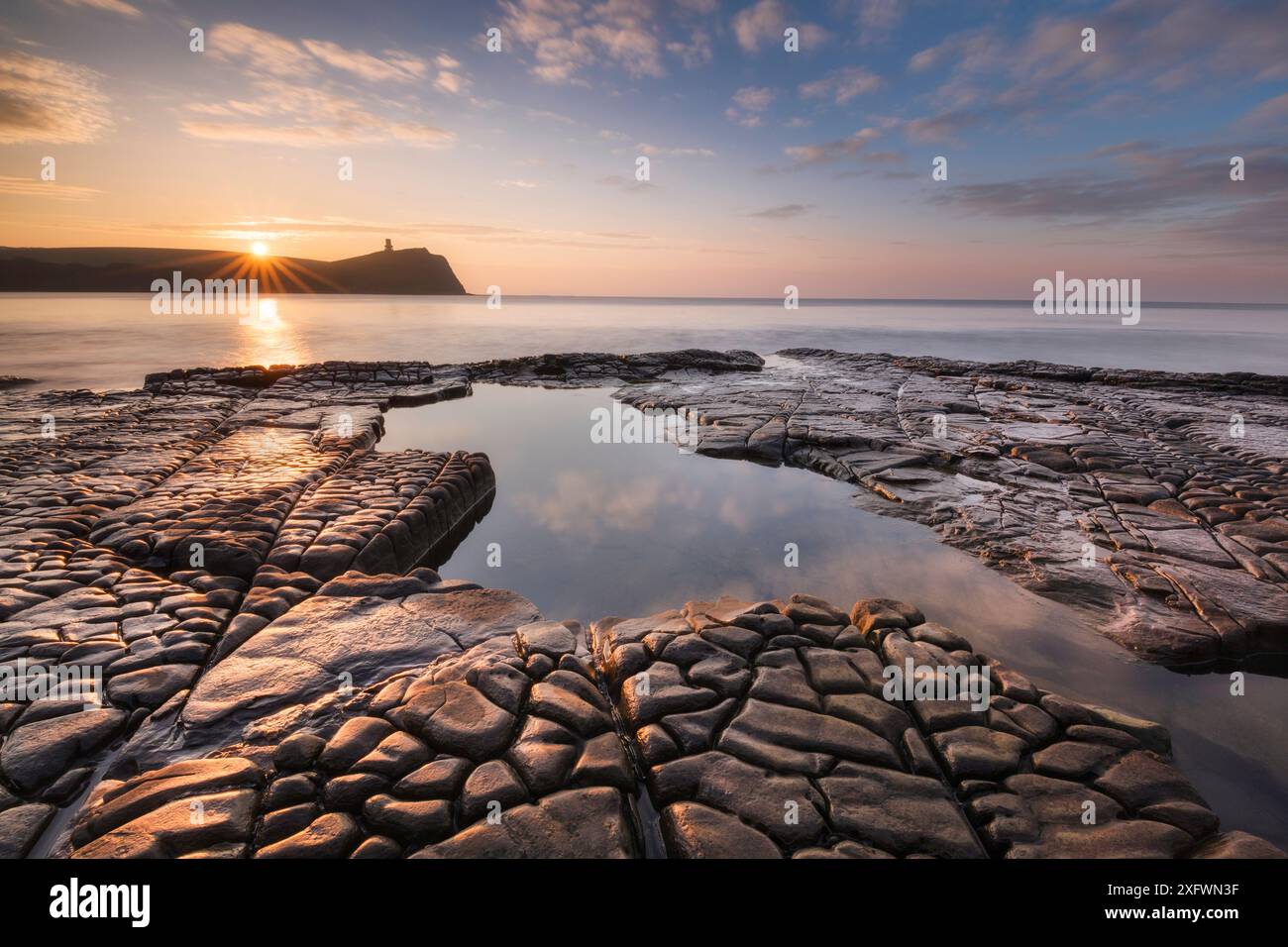 Rocky shore at Kimmeridge Bay with Clavell Tower in background, Isle of ...