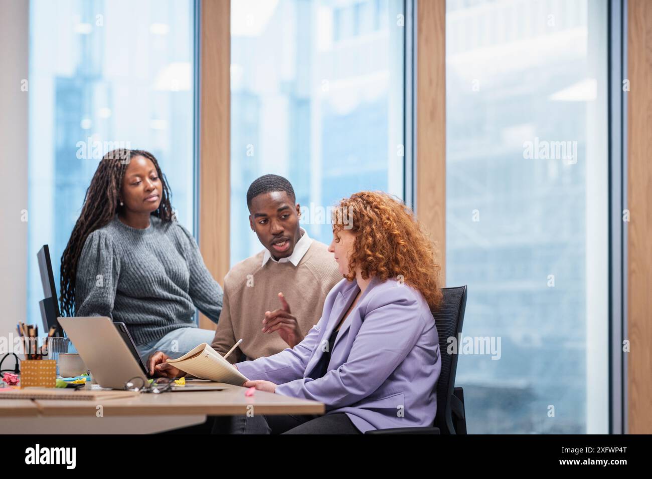 Corporate colleagues sharing strategies while working in office Stock ...