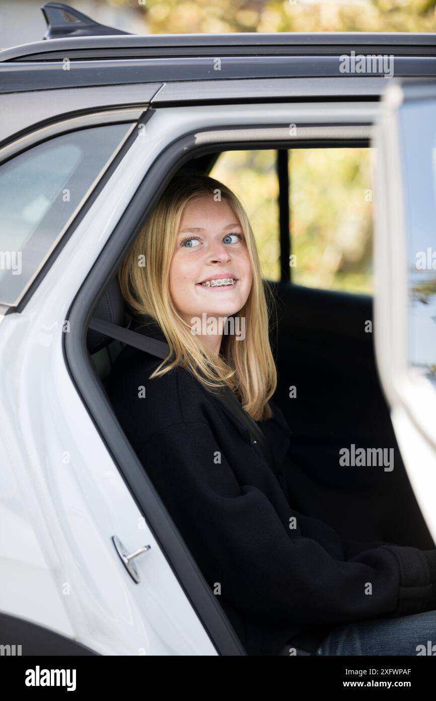 Smiling teenage girl sitting in car Stock Photo - Alamy
