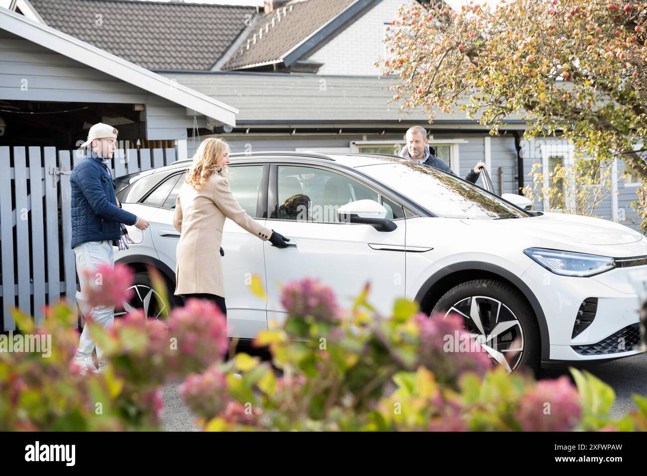 Family moving in white electric car outside house Stock Photo - Alamy