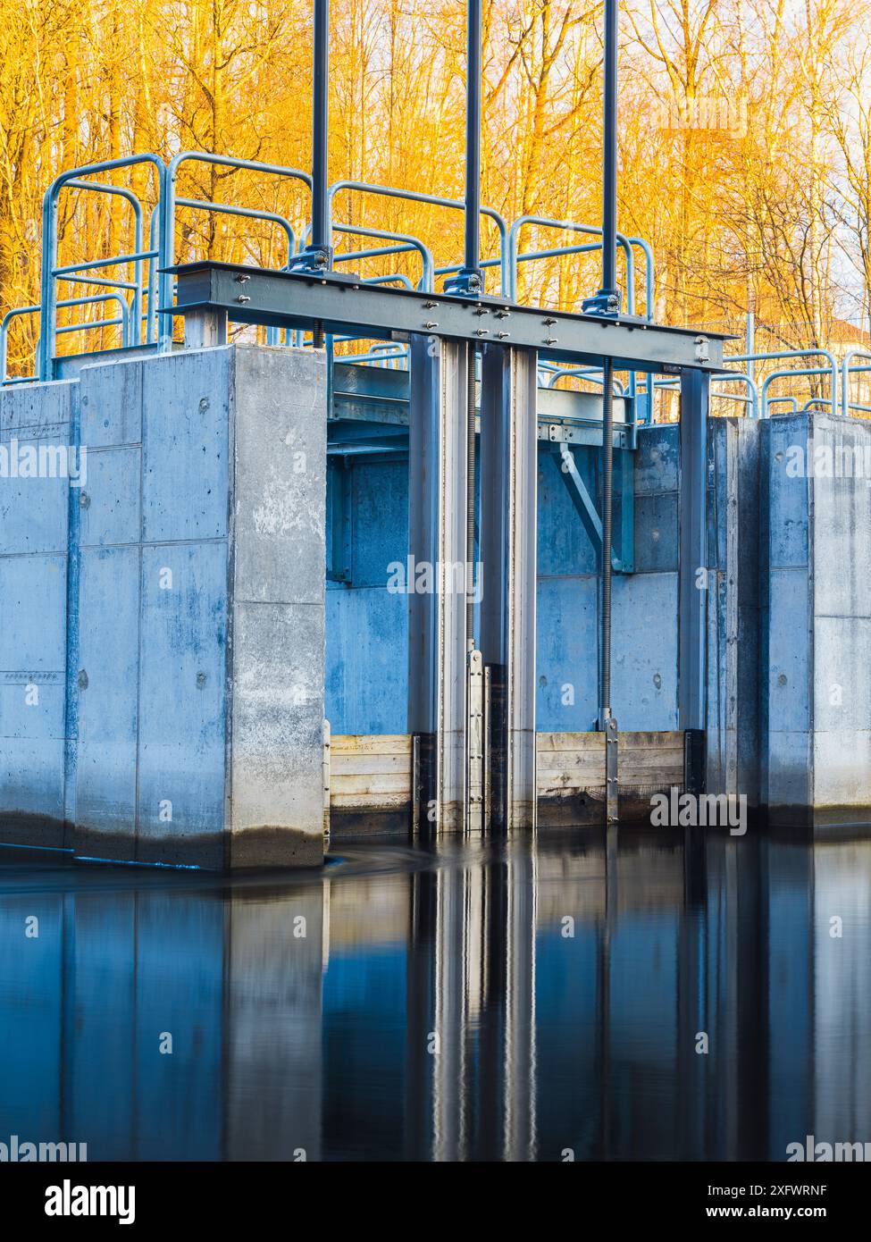 Machinery with reflection on water at dam Stock Photo - Alamy