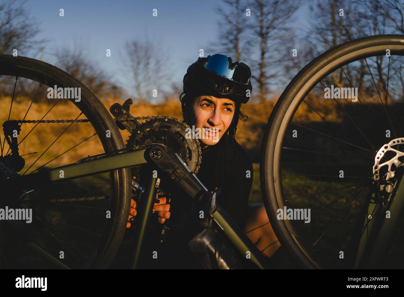 Tired female cyclist repairing bicycle at back yard Stock Photo - Alamy