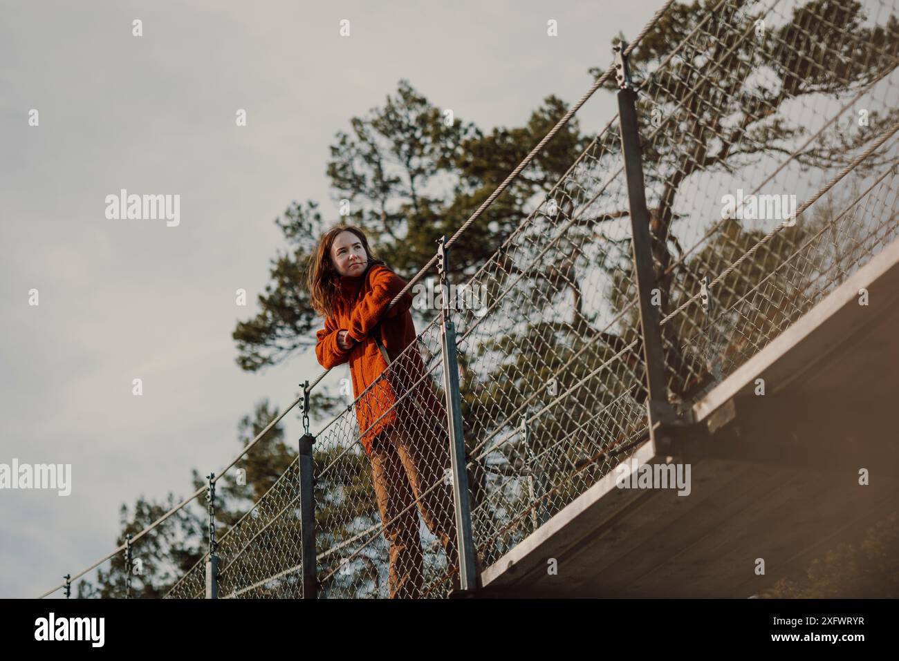 Low angle view of young woman leaning on railing Stock Photo - Alamy