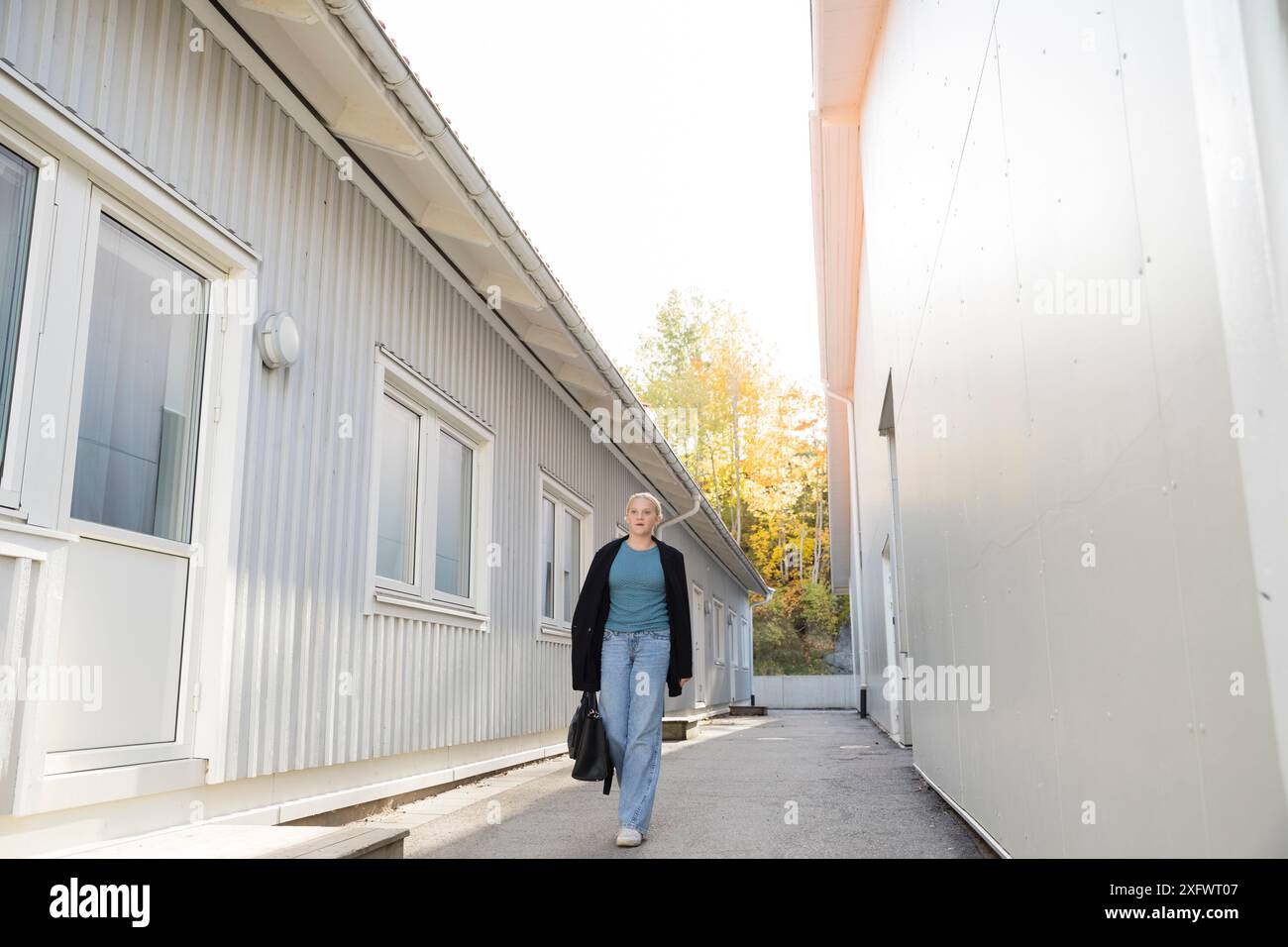 Teenage girl walking through passageway at school building Stock Photo ...