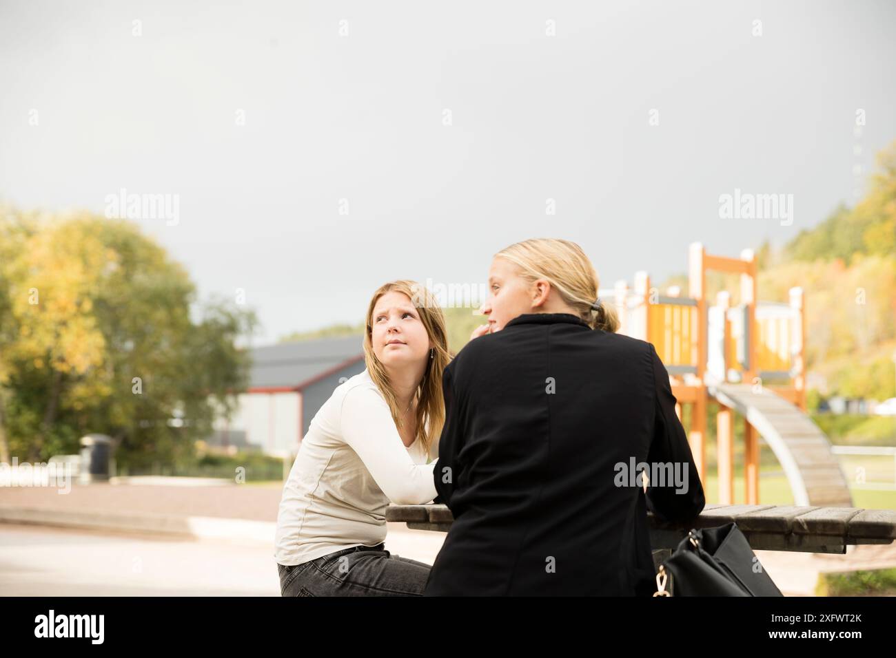 Friends looking over shoulder at schoolyard Stock Photo - Alamy