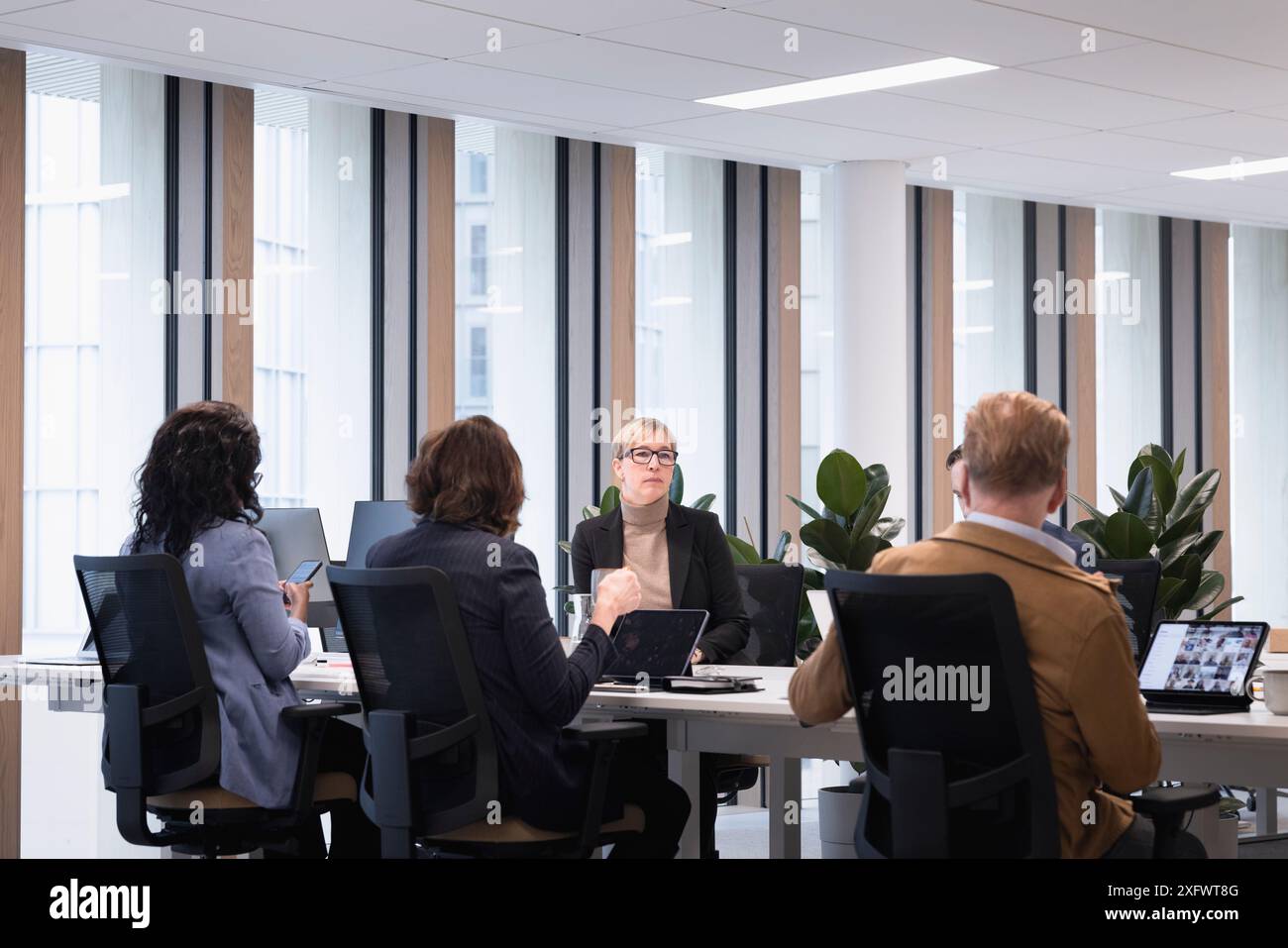Corporate coworkers discussing over conference table in office Stock ...