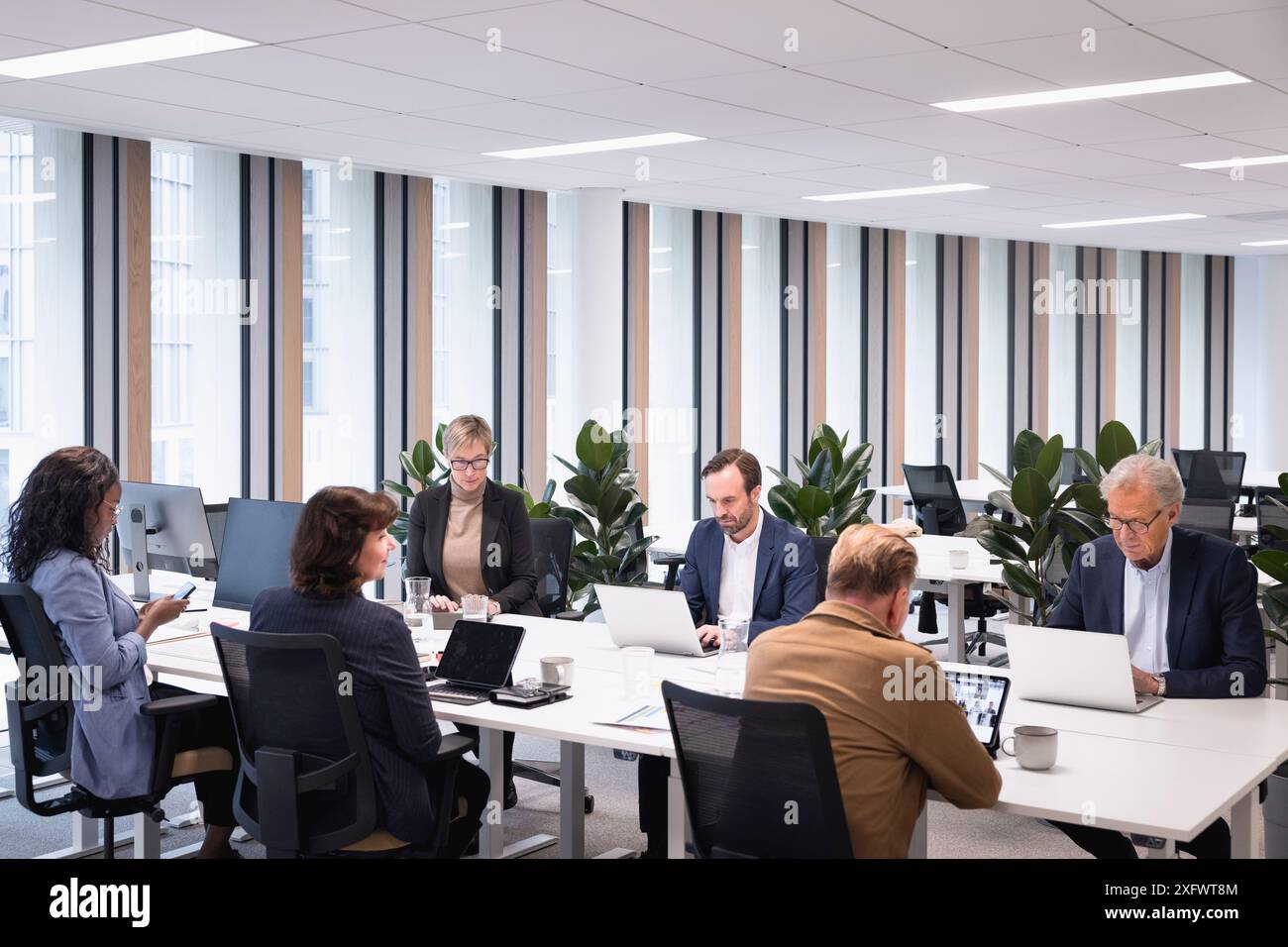 Corporate colleagues working over conference table in office Stock ...