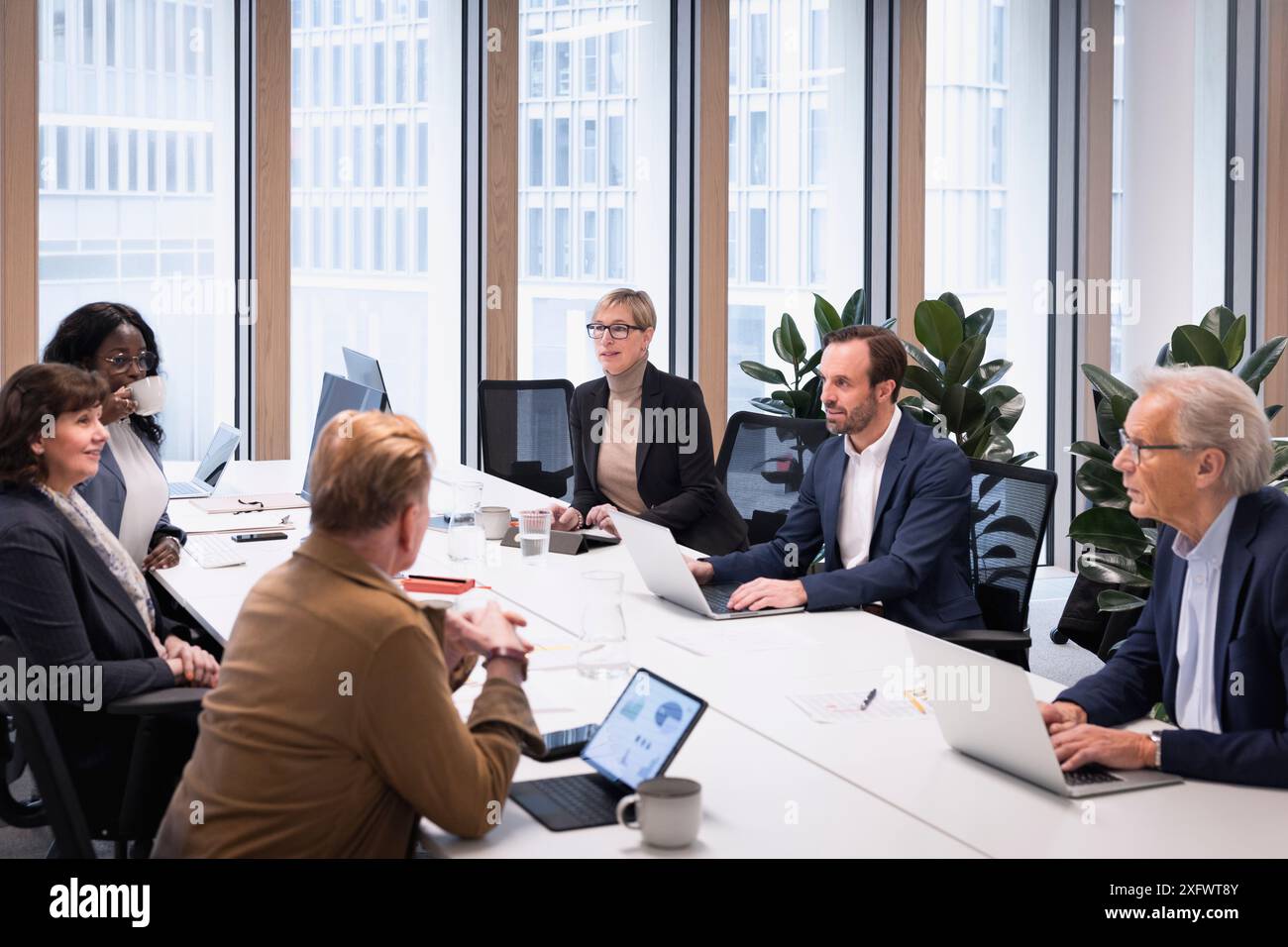 Multiracial business people discussing over conference table in office ...