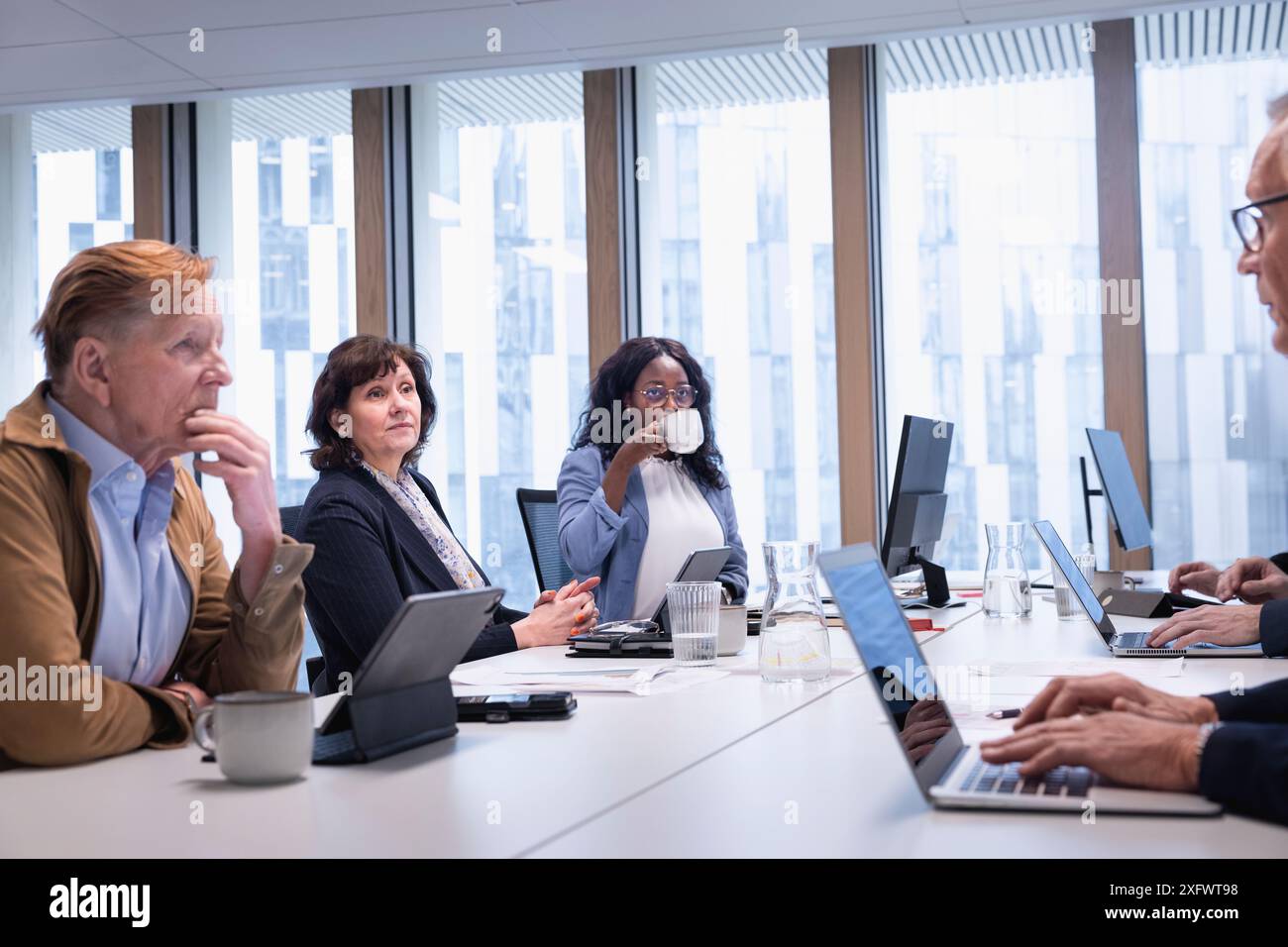 Multiracial colleagues discussing over conference table during meeting ...