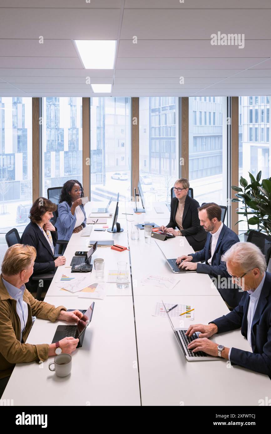 Multiracial corporate colleagues discussing over conference table in ...