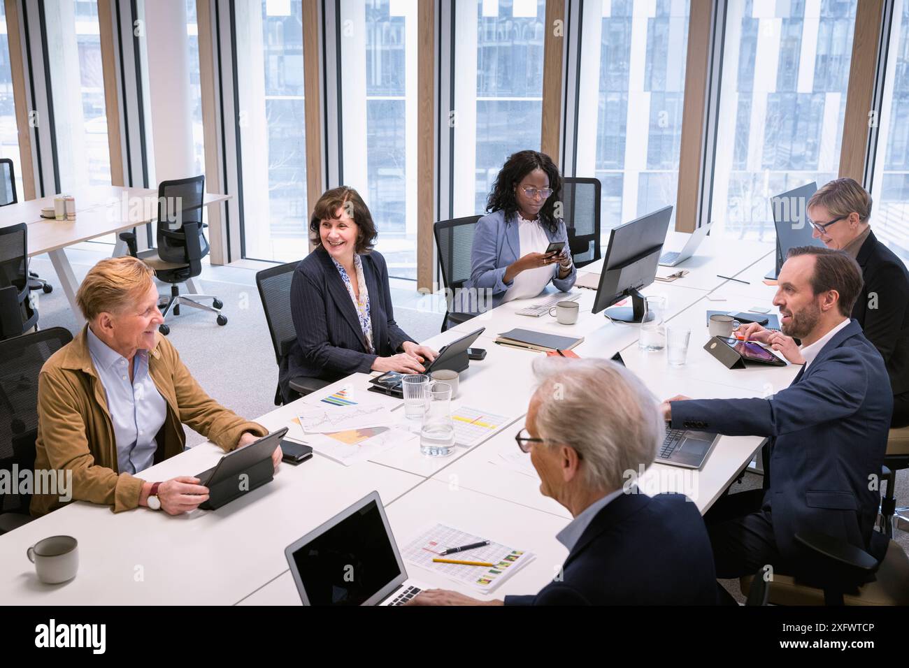 Multiracial colleagues sharing ideas with over conference table in ...