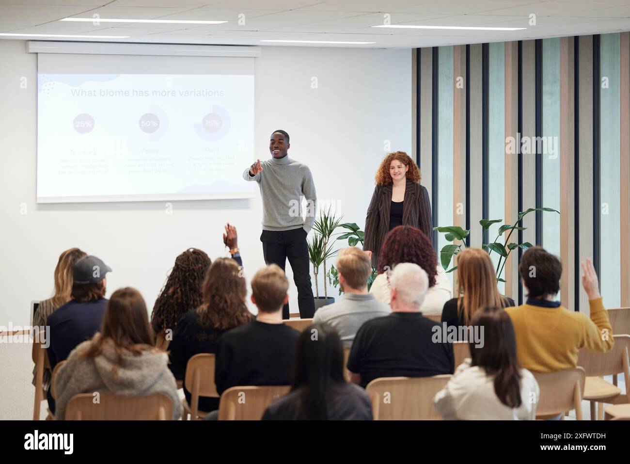 Multiracial colleagues giving presentation to employees in office Stock ...