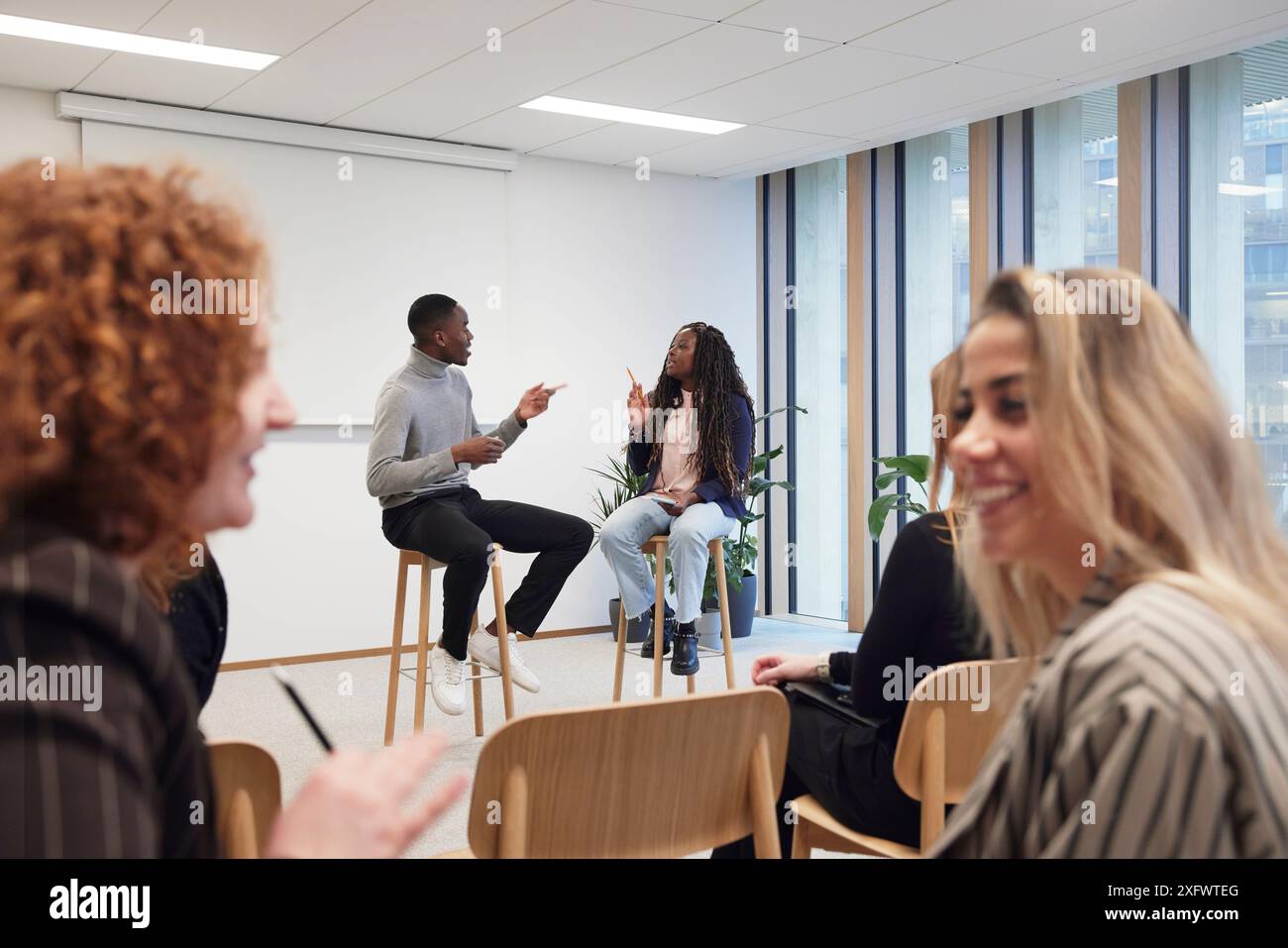 Multiracial corporate colleagues sharing ideas during meeting in office ...