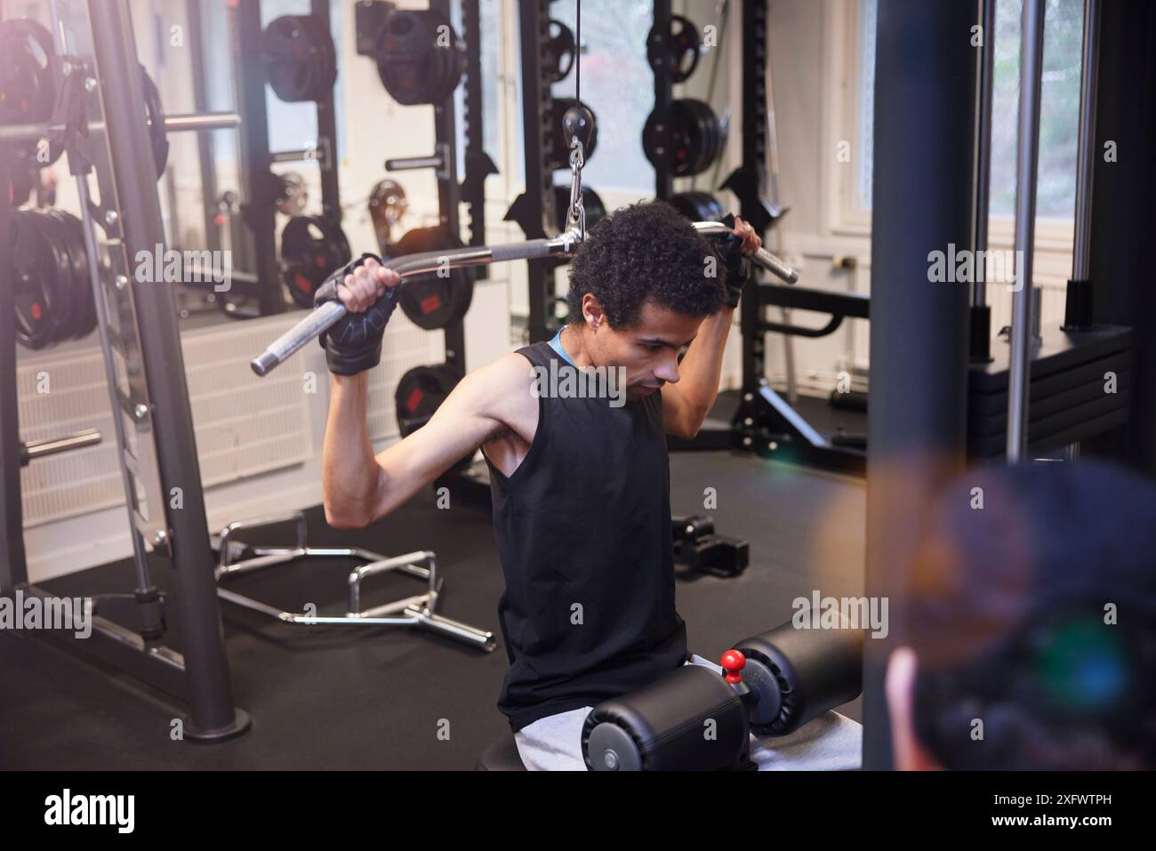 Young man doing lateral pull-down weightlifting at gym Stock Photo - Alamy