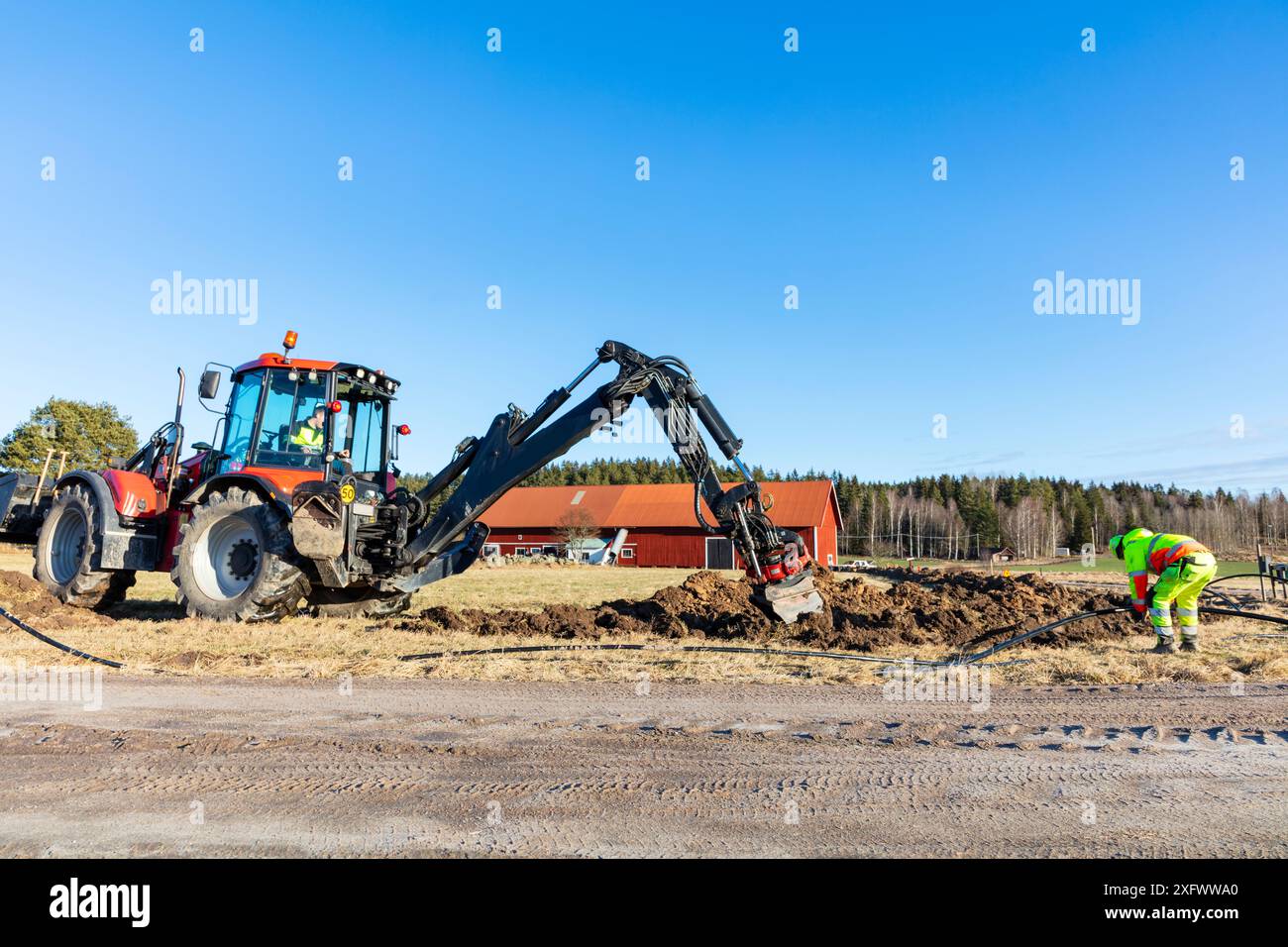 Maintenance engineer removing dirt with backhoe from ground on sunny ...
