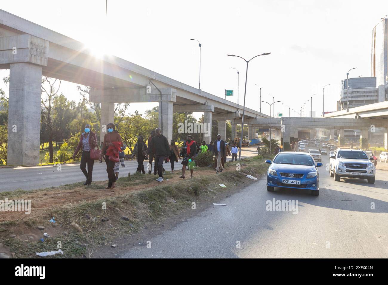 Nairobi, Kenya - June 25th, 2024. Commuters walk home from the city ...