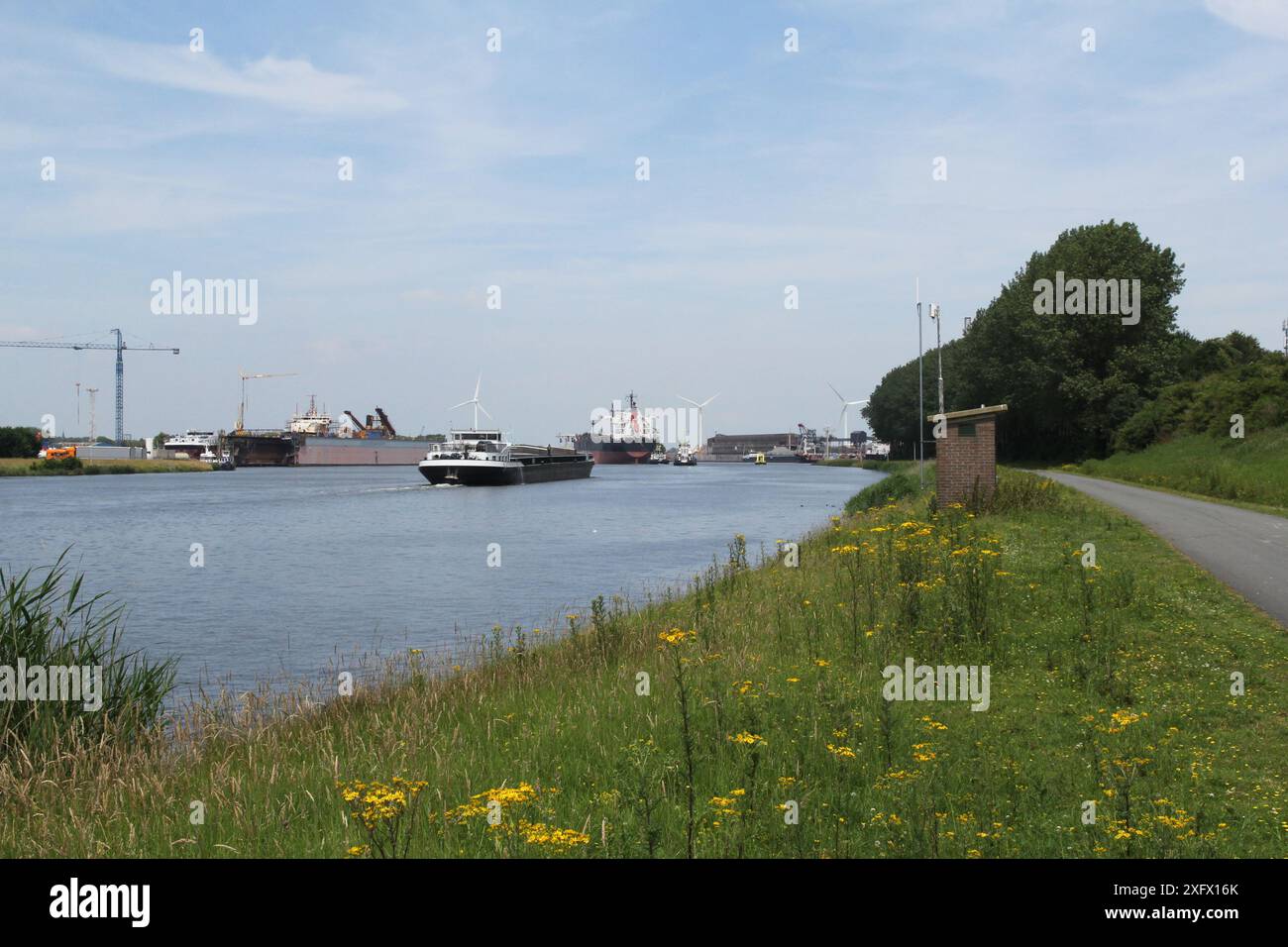 a beautiful landscape of canal Ghent-Terneuzen with a barge and a big ...